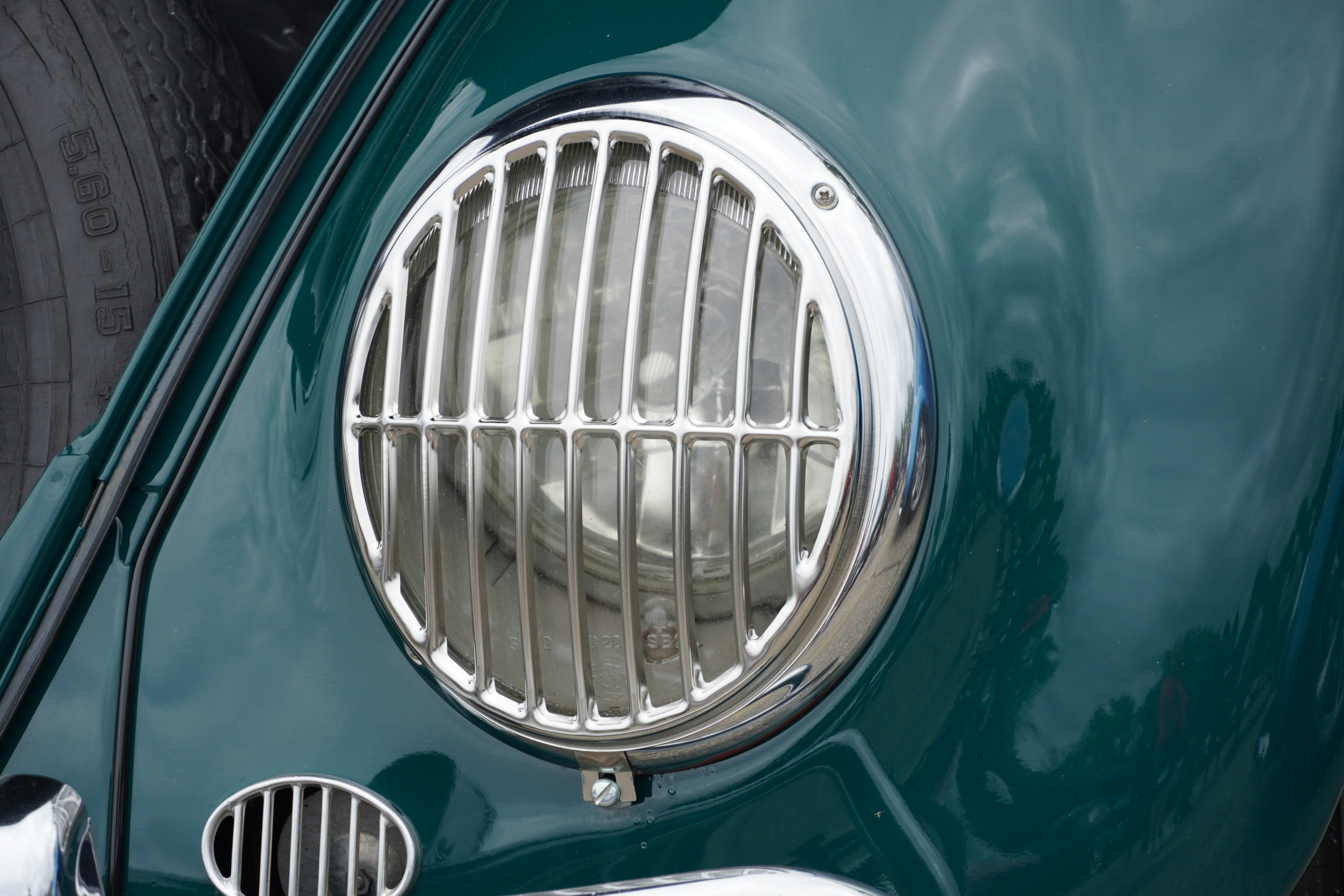 Vintage car headlight with a chrome grille.