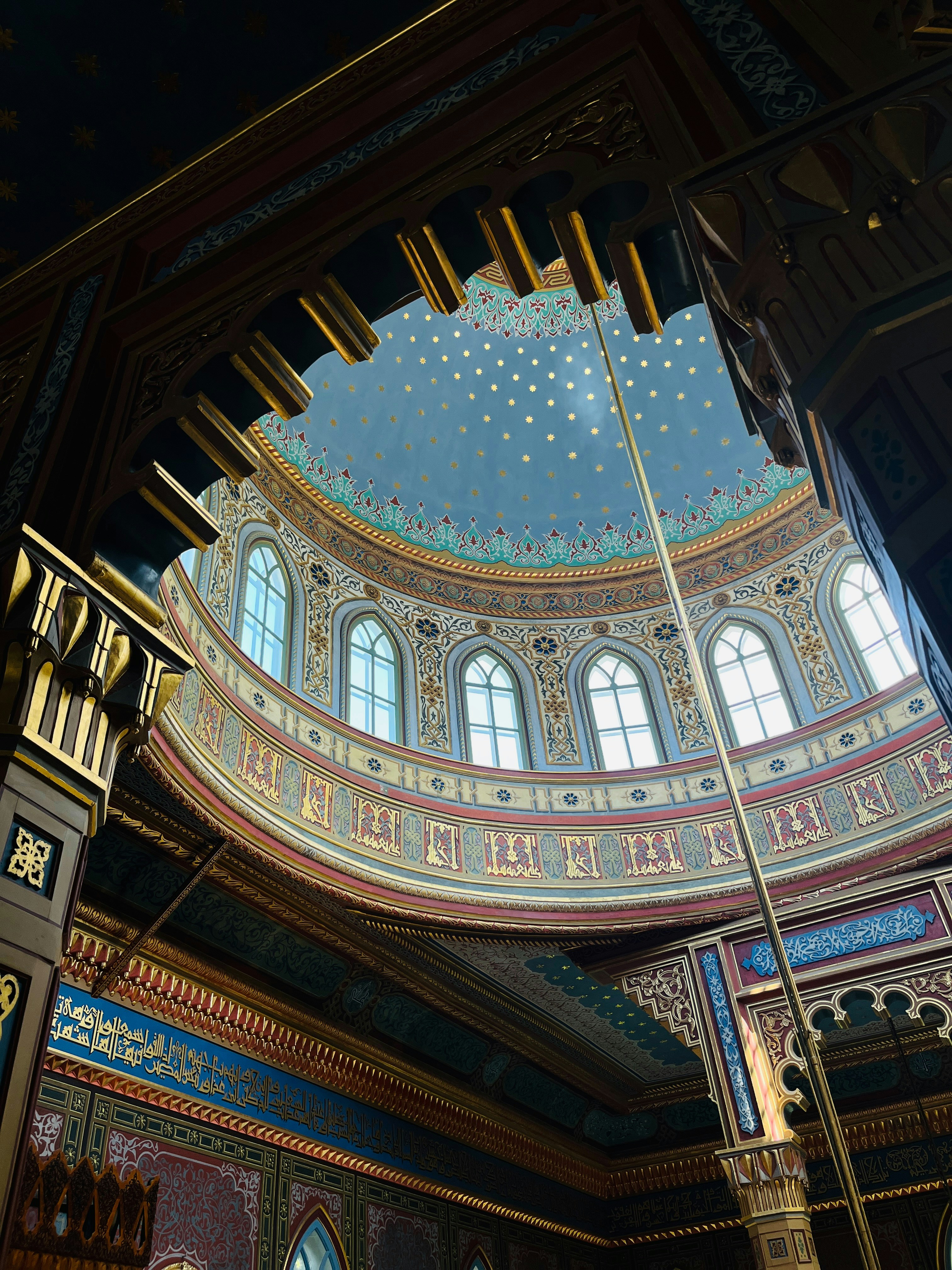 Ornate dome ceiling with arched windows and starry blue design.