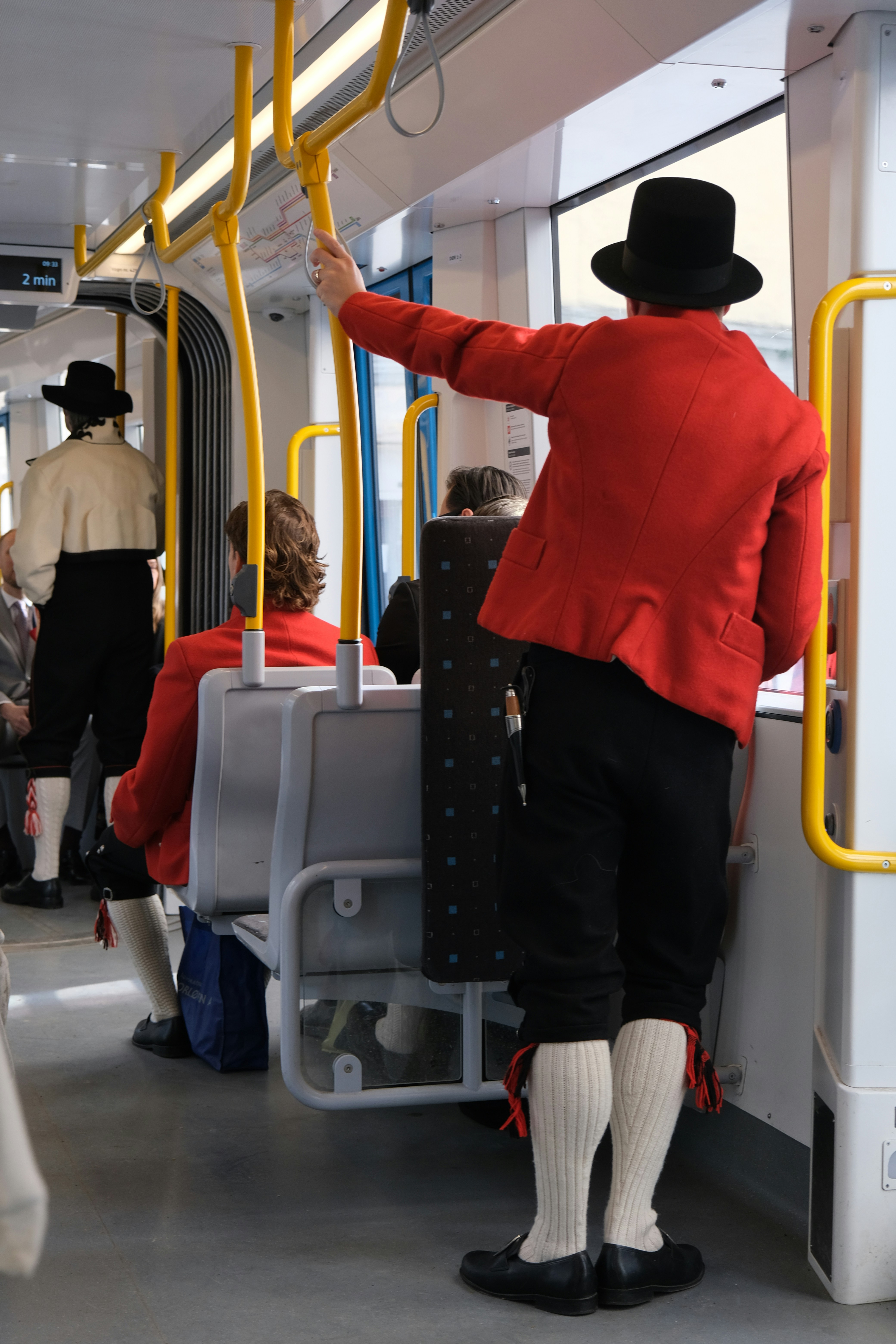 Red-clad conductor in a train: a portrait of showmanship among commuters