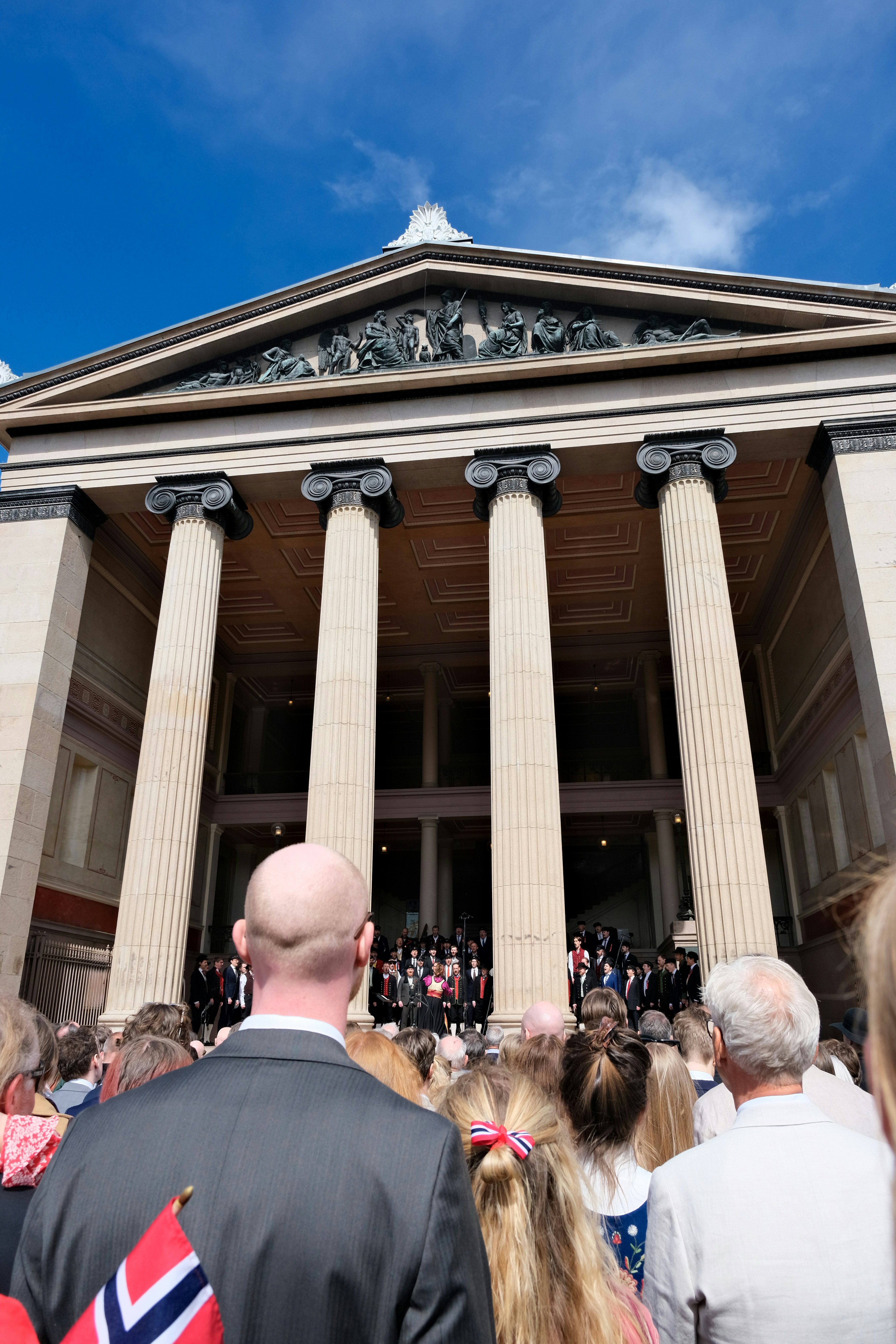 Crowd Gathers at the Steps of a Grand Classical Facade