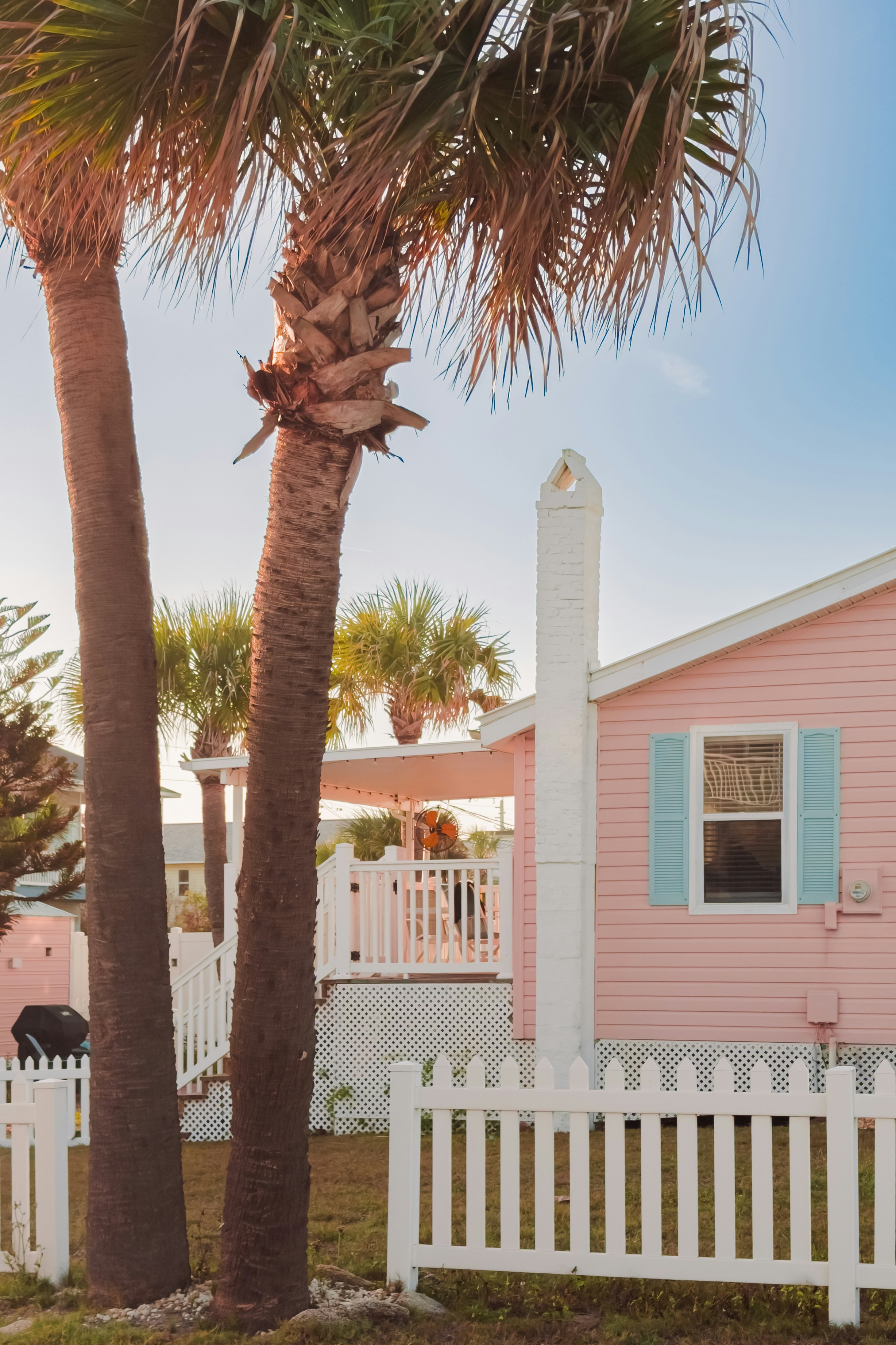 A charming pink cottage glowing in warm afternoon sunlight