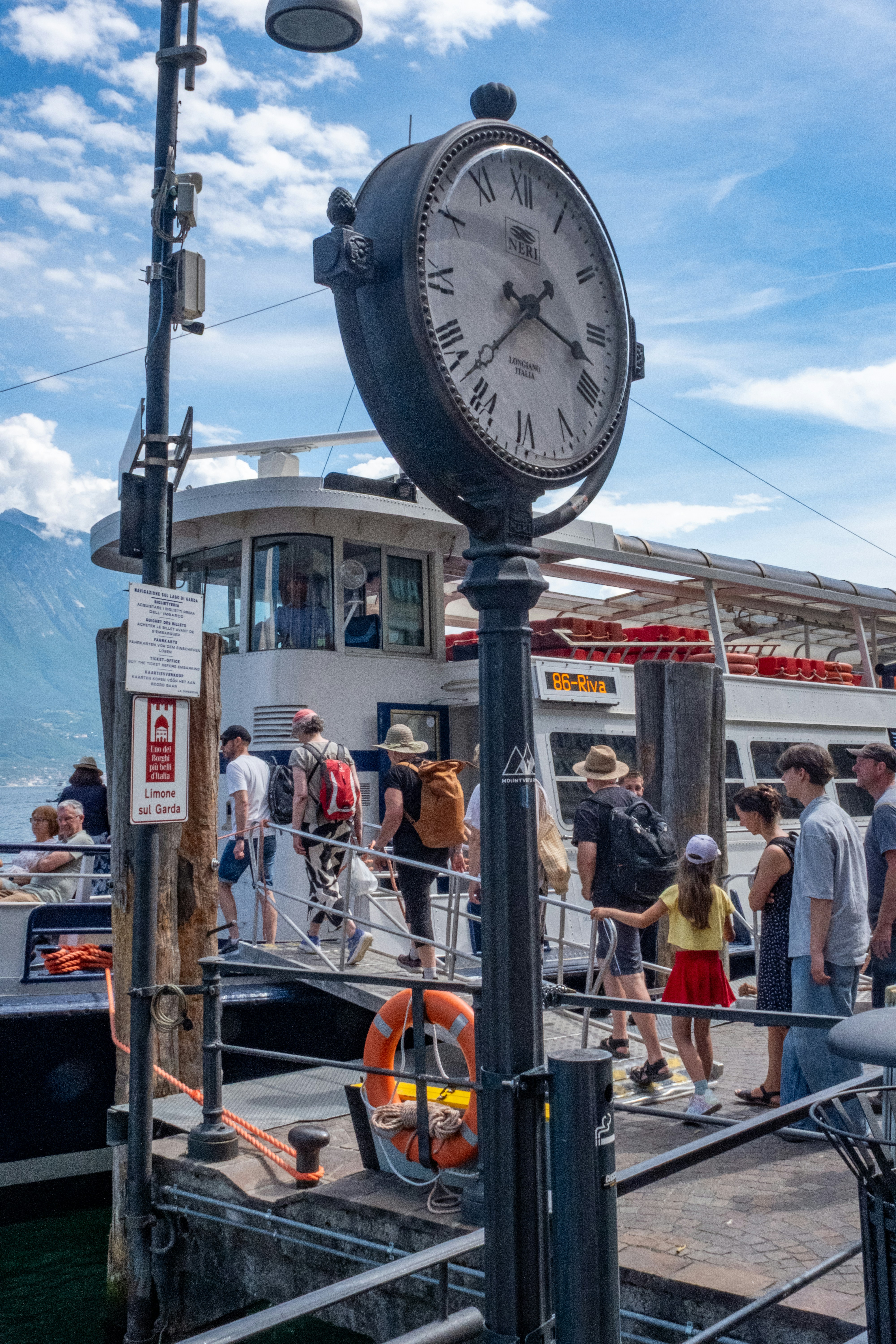 Timekeeper at the Dock: Passengers Gather beneath a Lantern-Clock