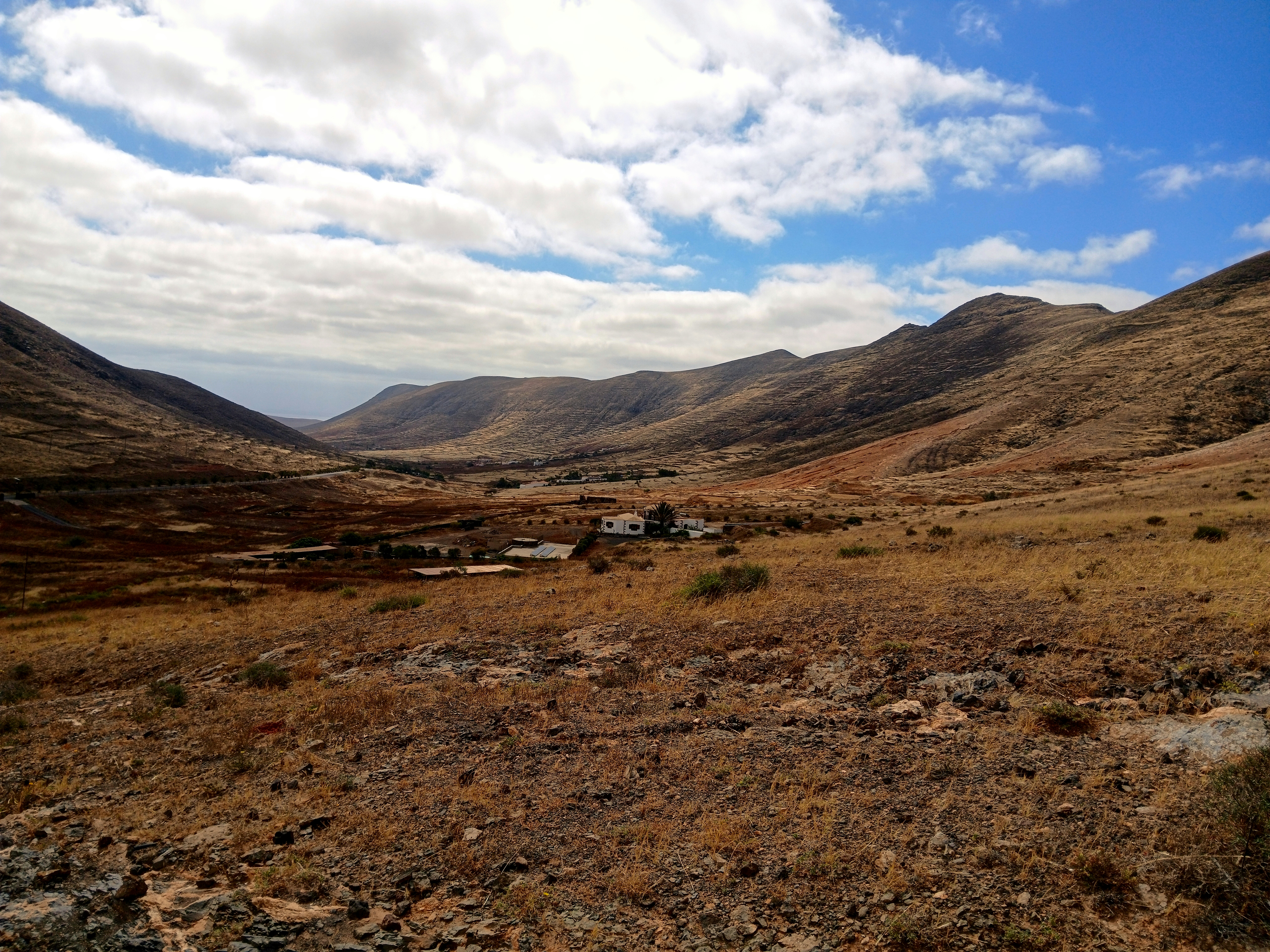 Desert Valley Road Toward Distant Hills under a Patchy Sky
