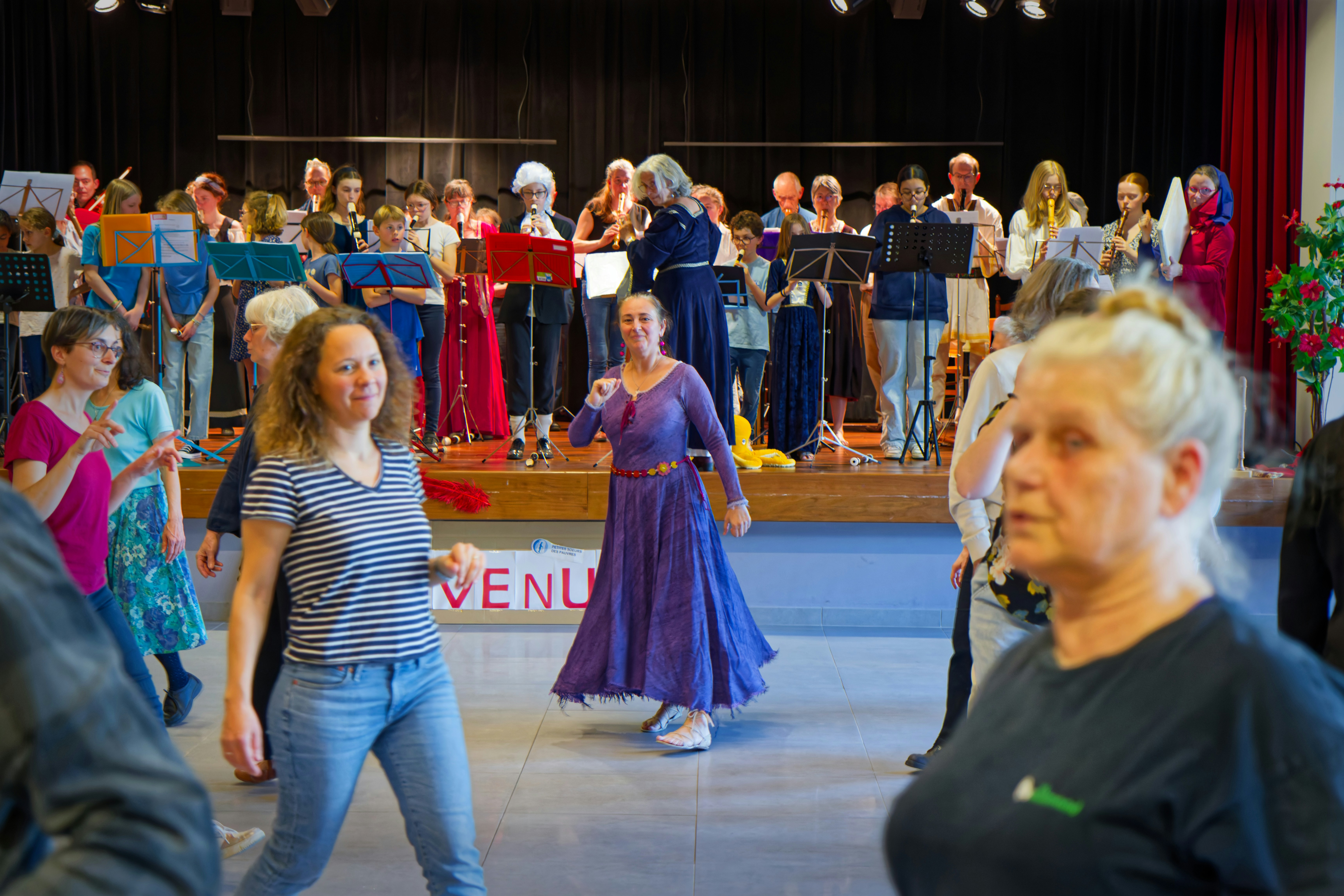 Dancers in a Community Hall: A Colorful Rehearsal under Soft Stage Lights