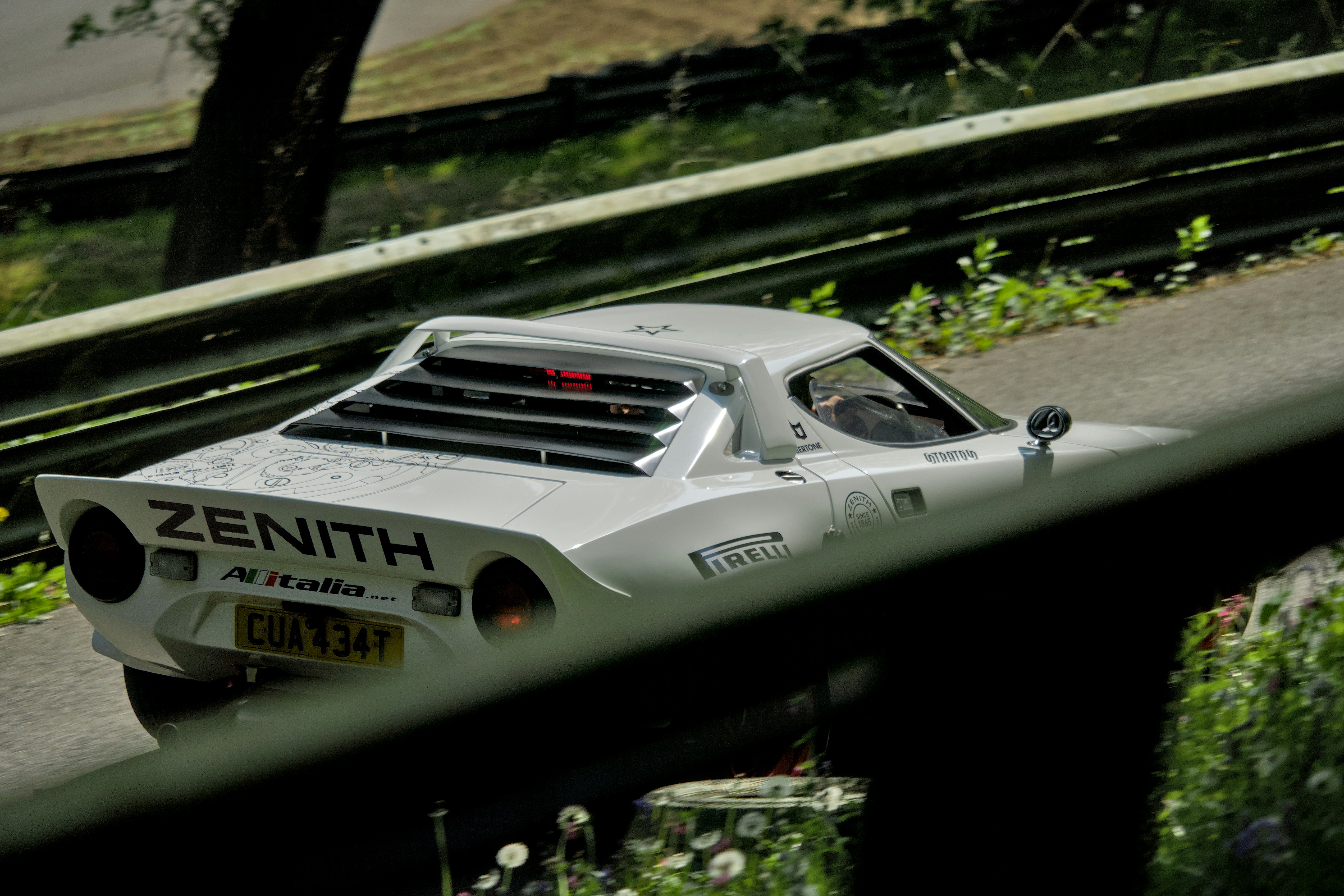 White lancia stratos sports car on a winding road.