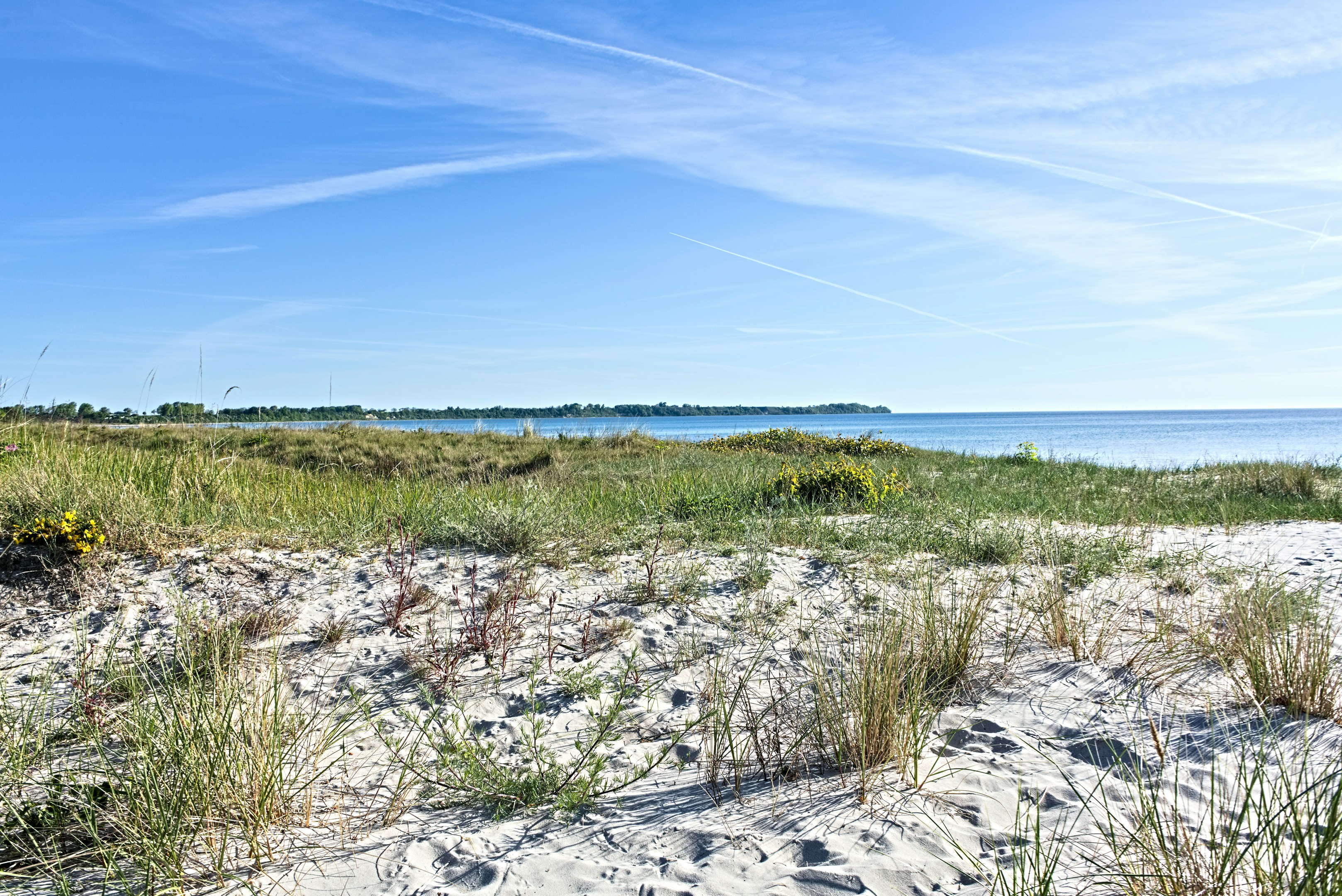 Dune Ribbon and Quiet Sea Under Wide Blue Sky