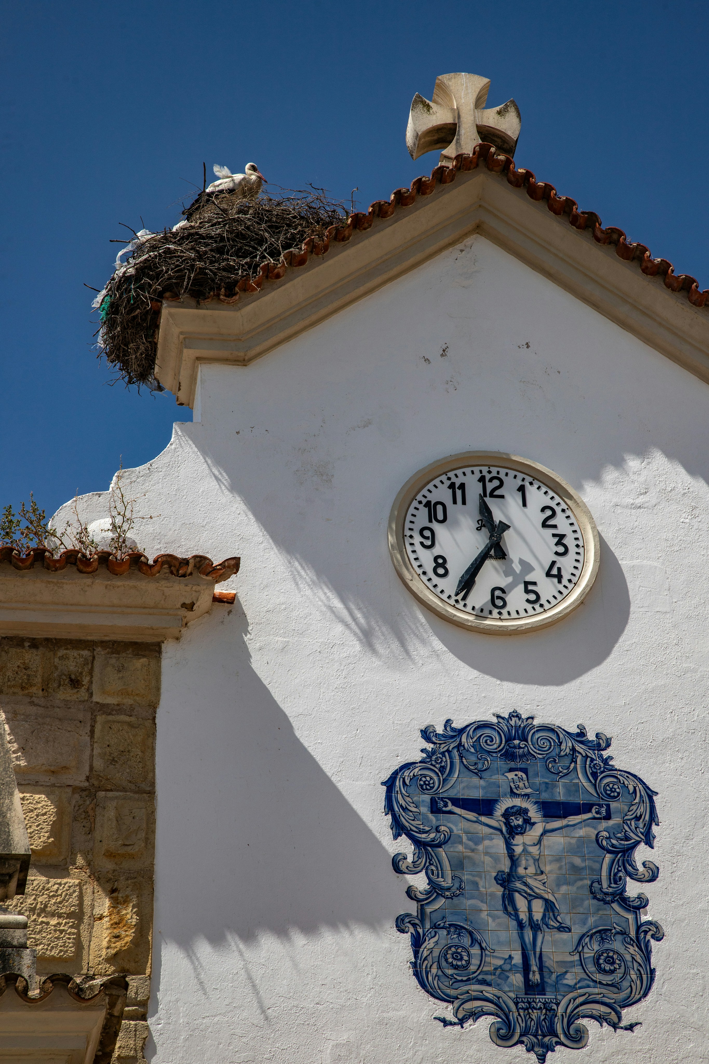 Stately Nest Beneath the Clock: A White-Walled Facade with Blues