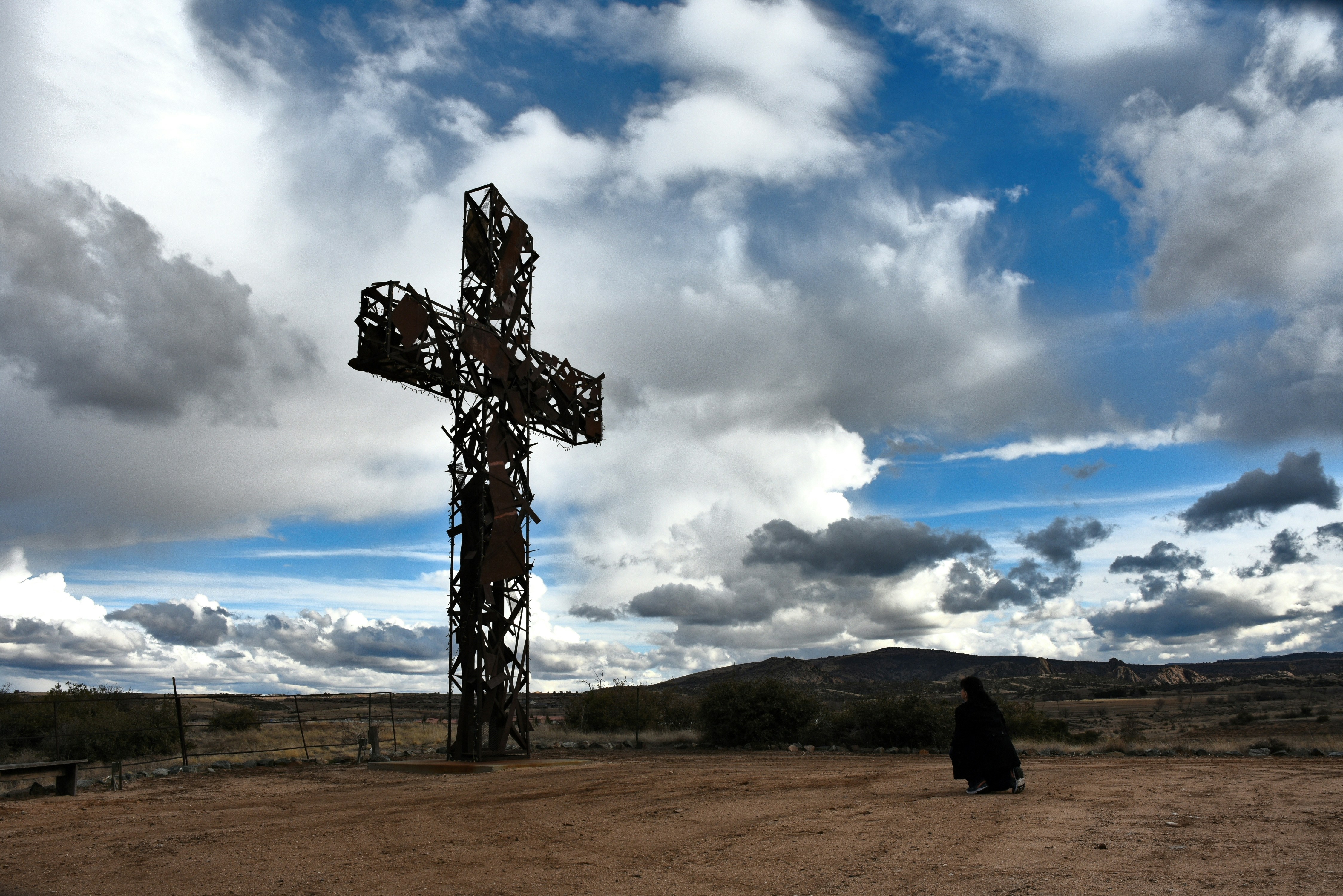 Iso Crossroads: A Lone Figure Beside a Weathered Metal Cross