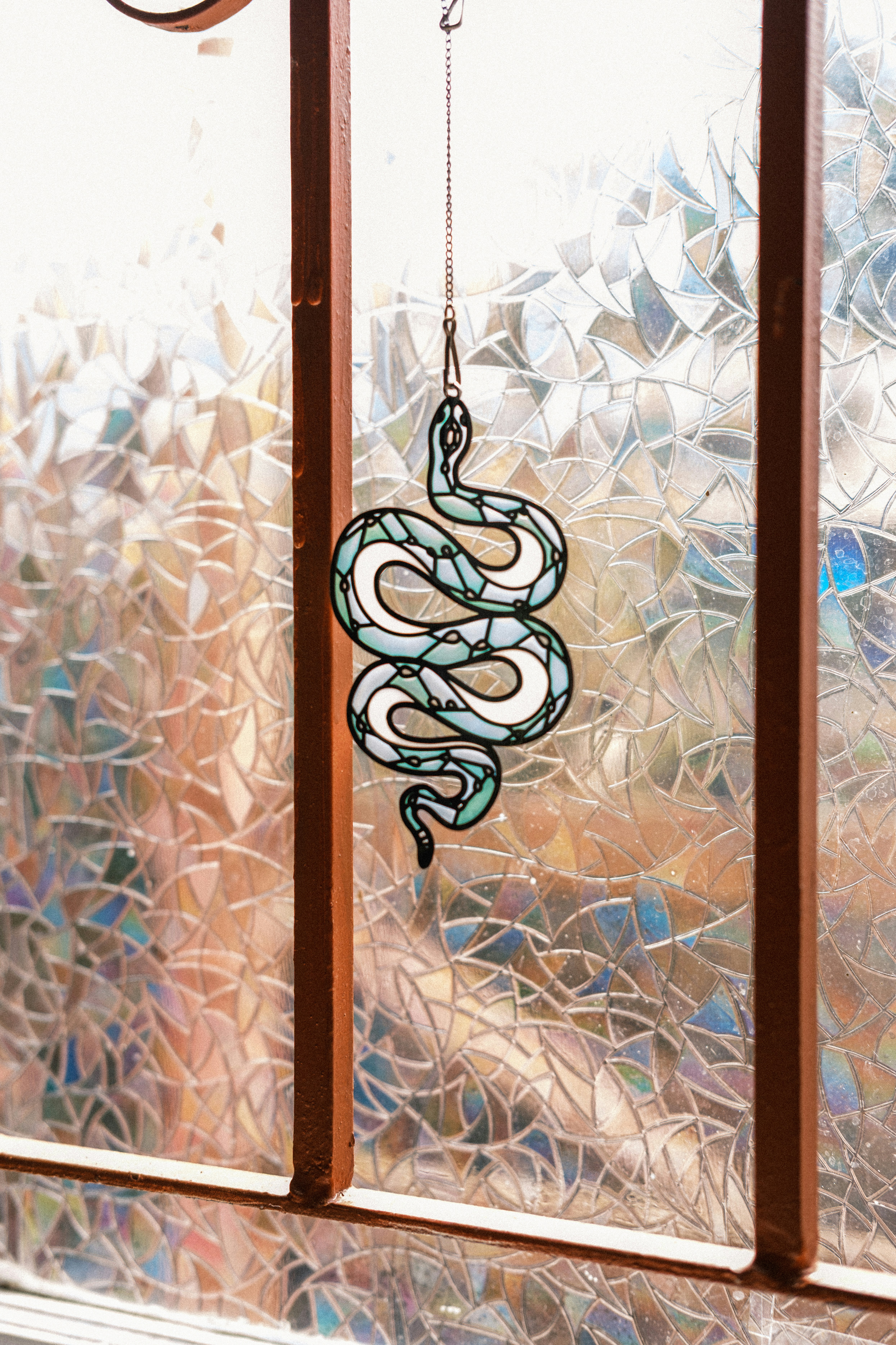 Pendant of the Serpent: Stained Glass Charm on Frosted Pane