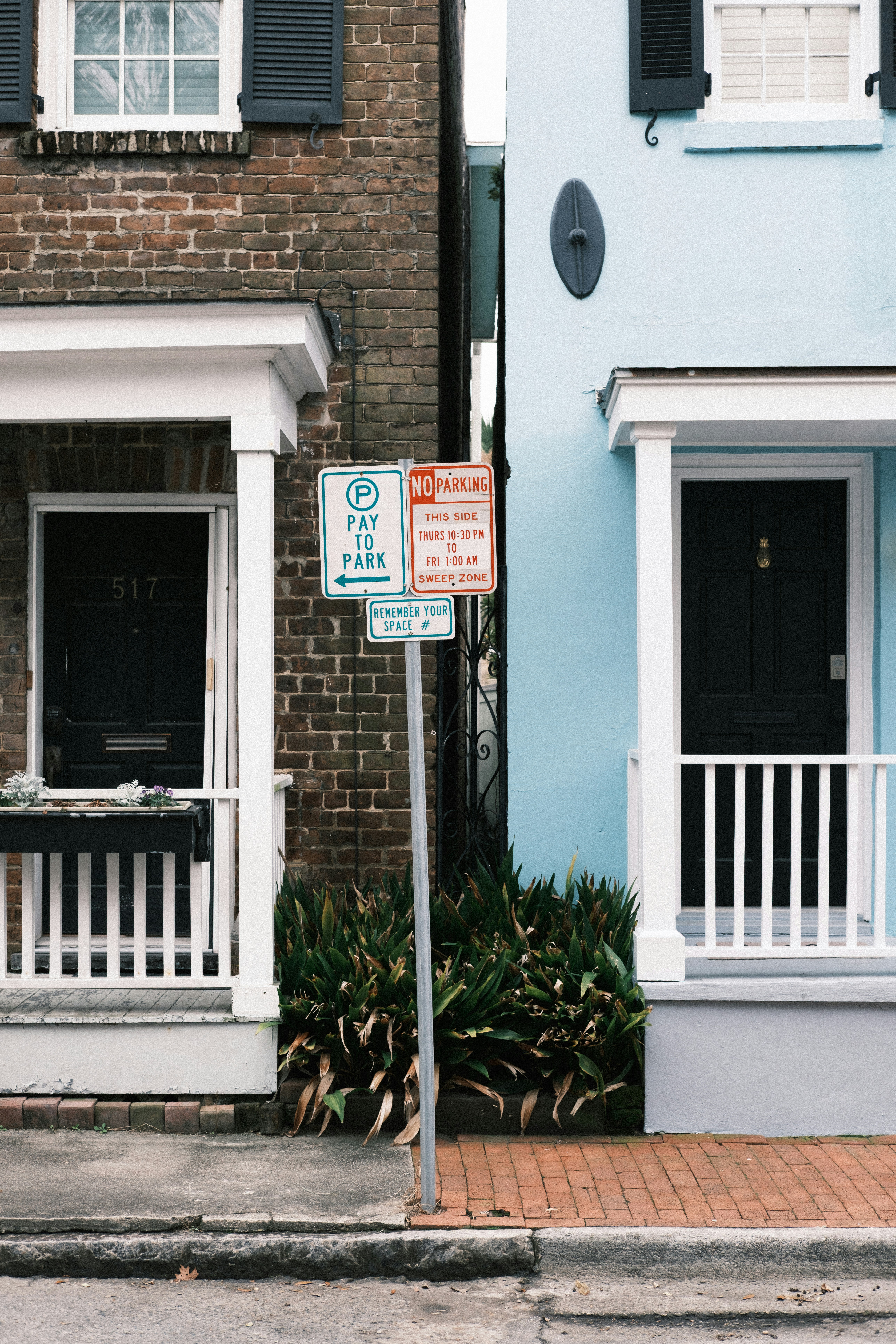 Two Facades and a Narrow Alley Between a Brick and a Blue House
