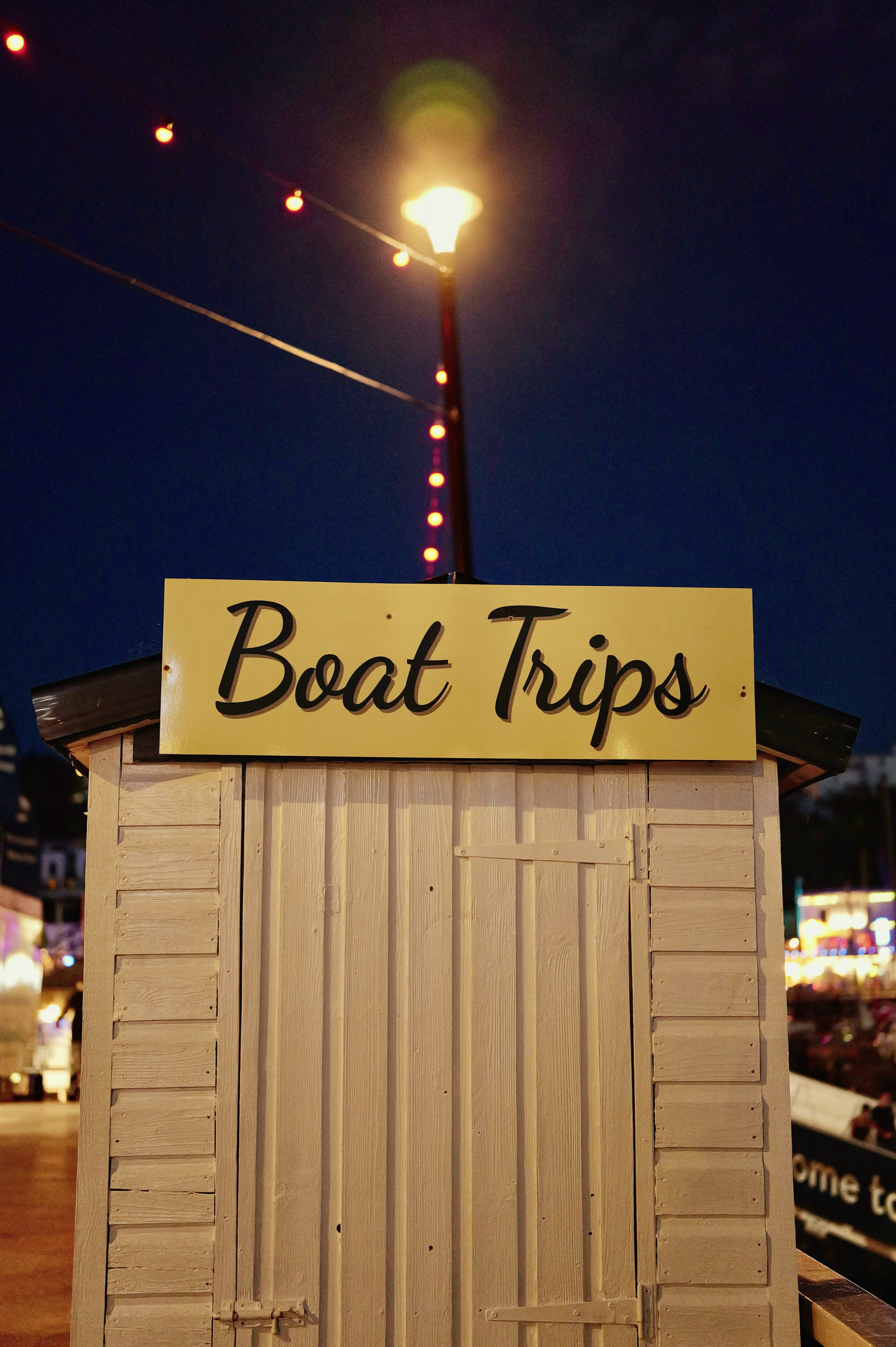 Night at the Booth: Boat Trip Sign Above Quiet Pier
