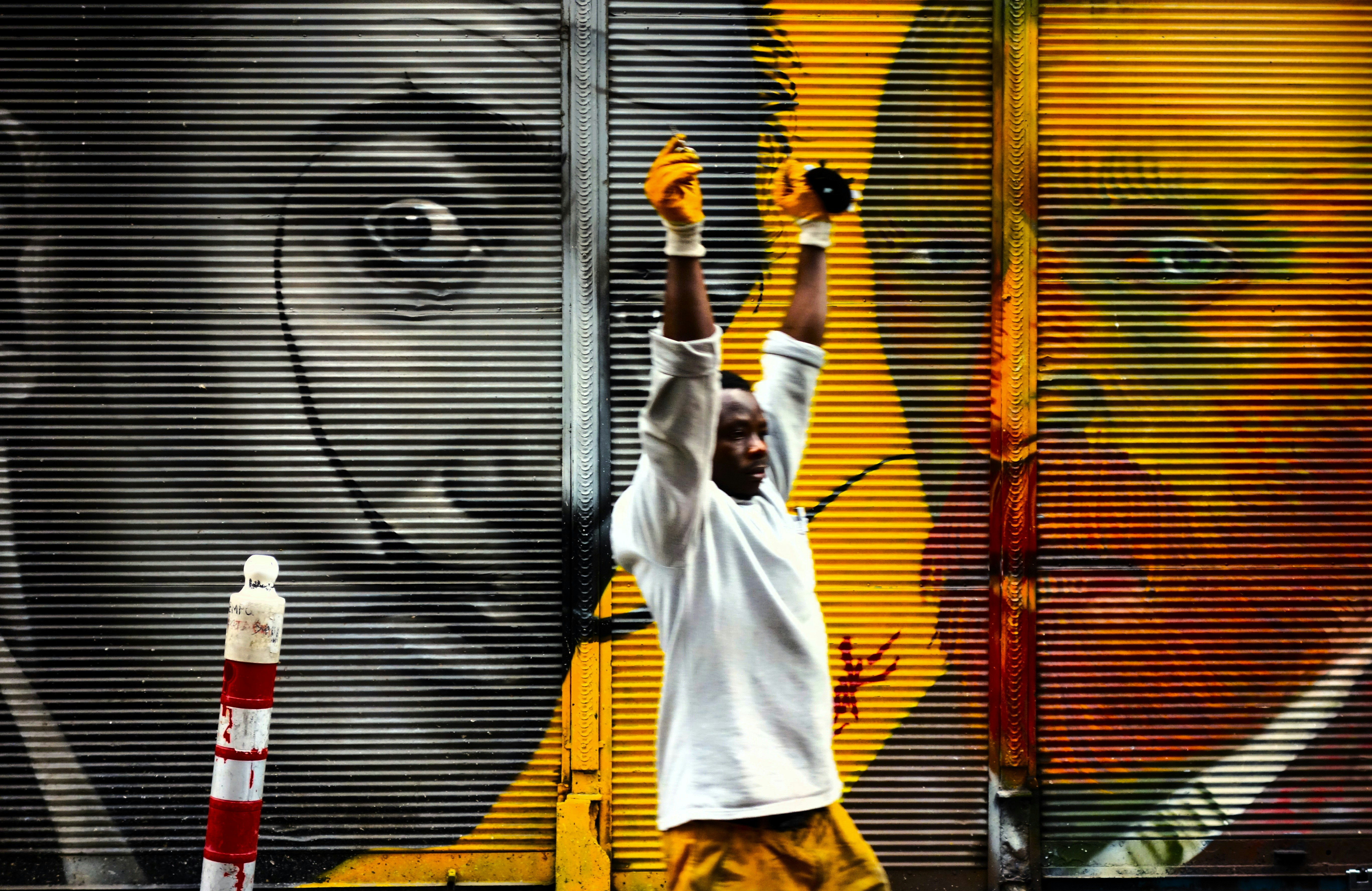 Raised Hands in Front of a Graffiti Portrait