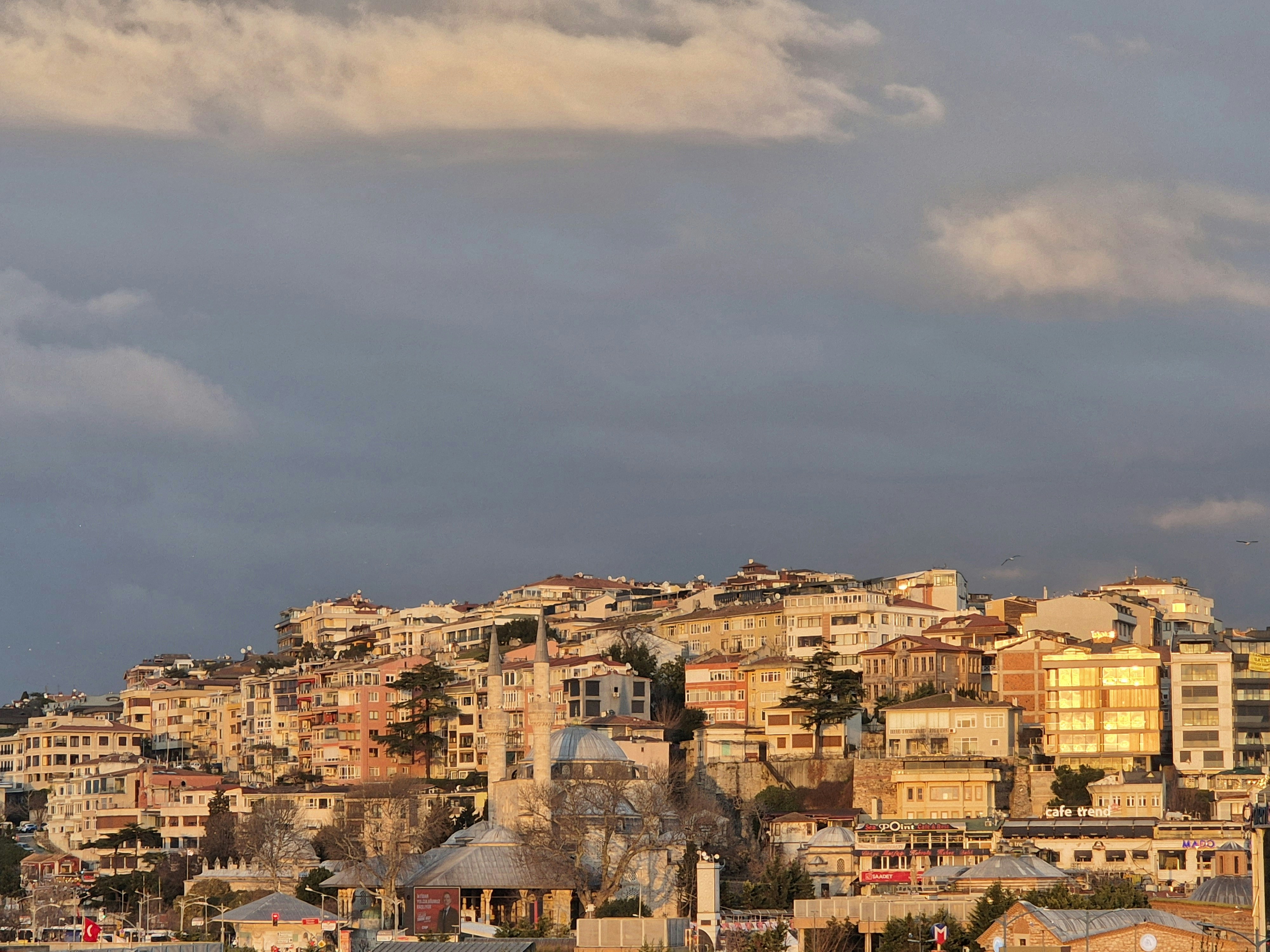 City buildings on a hillside bathed in warm sunlight.