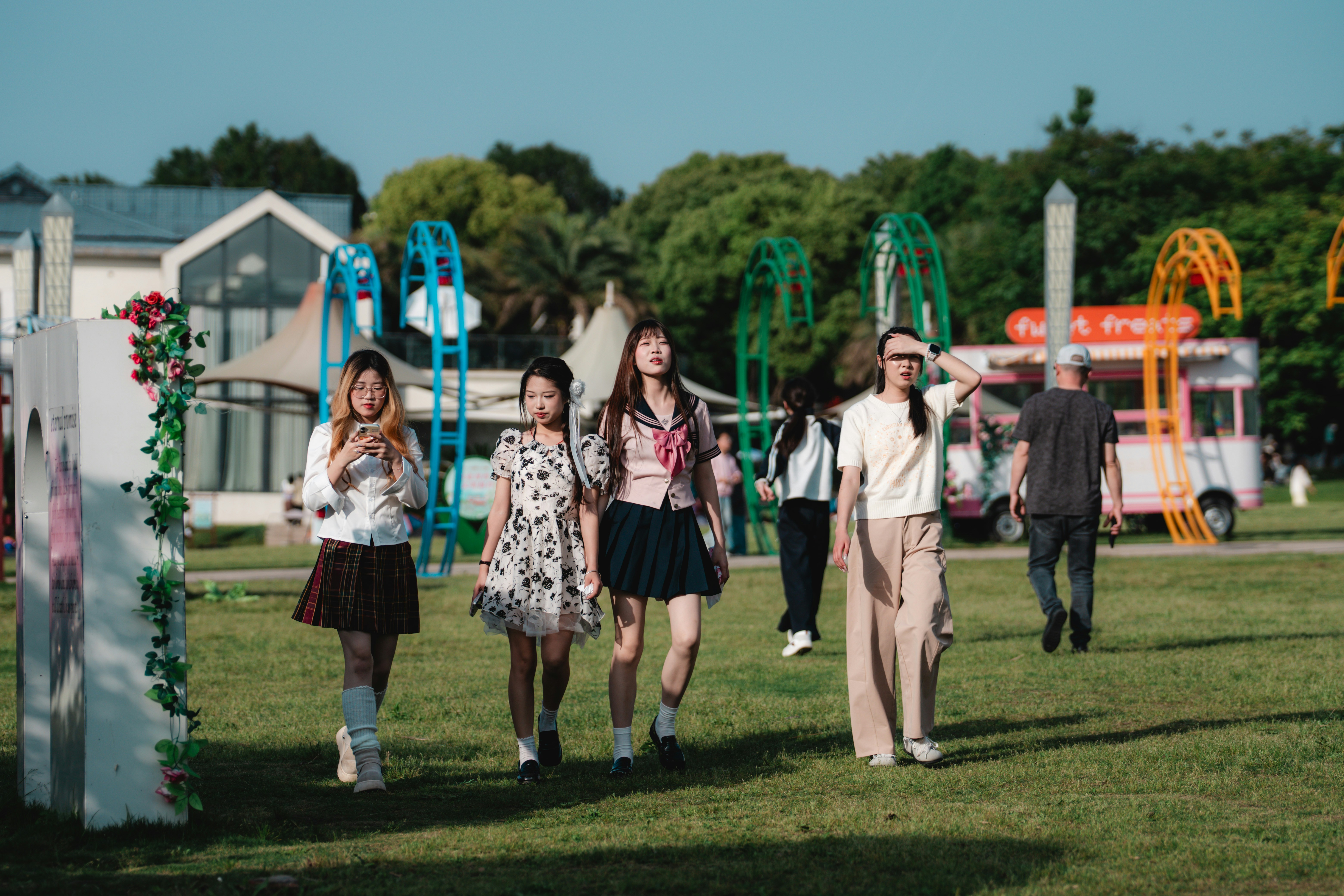 Sunlit Stroll: A Quartet of Friends in a Park Framed by Colorful Arcades