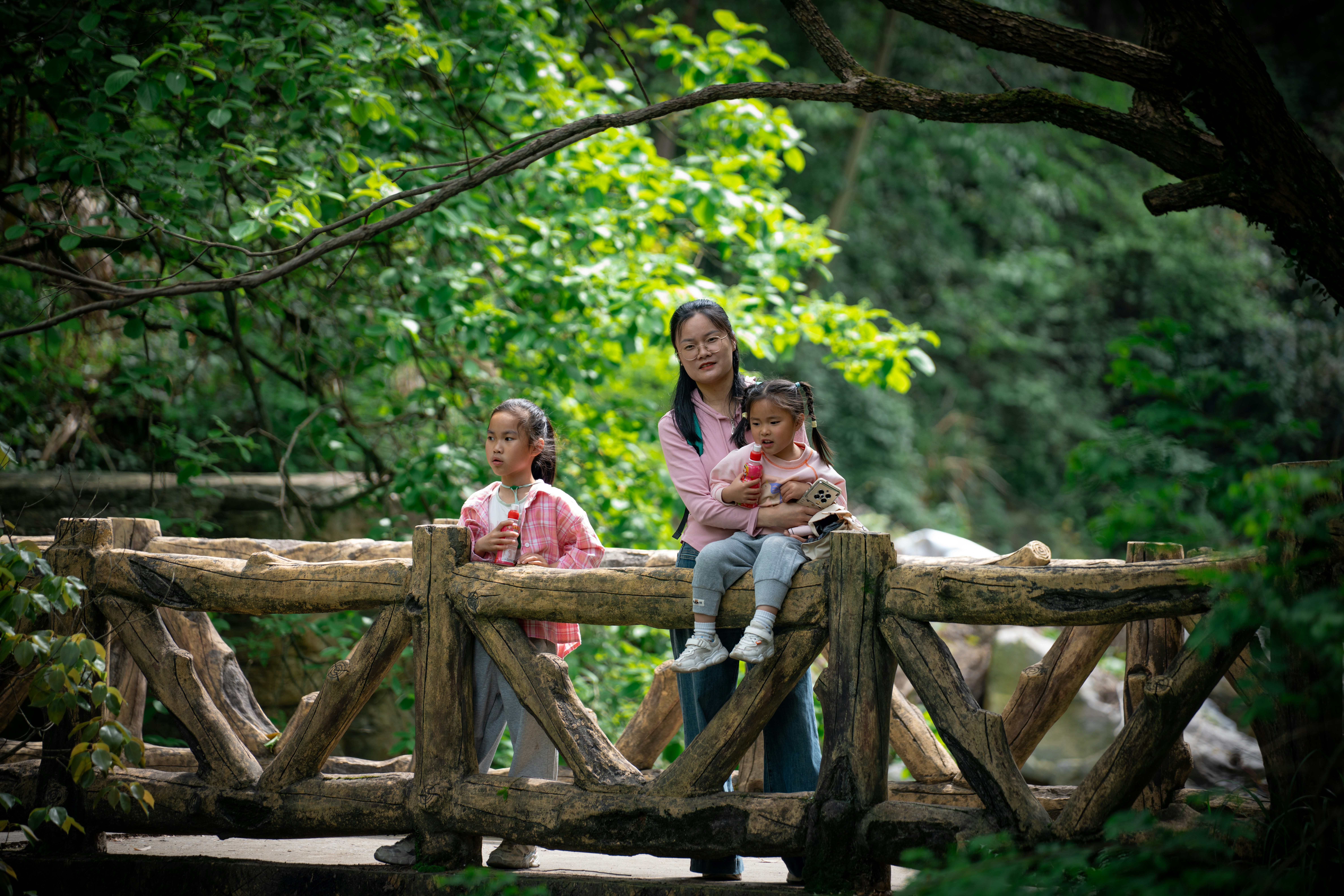 Family on a wooden bridge in a sunlit garden