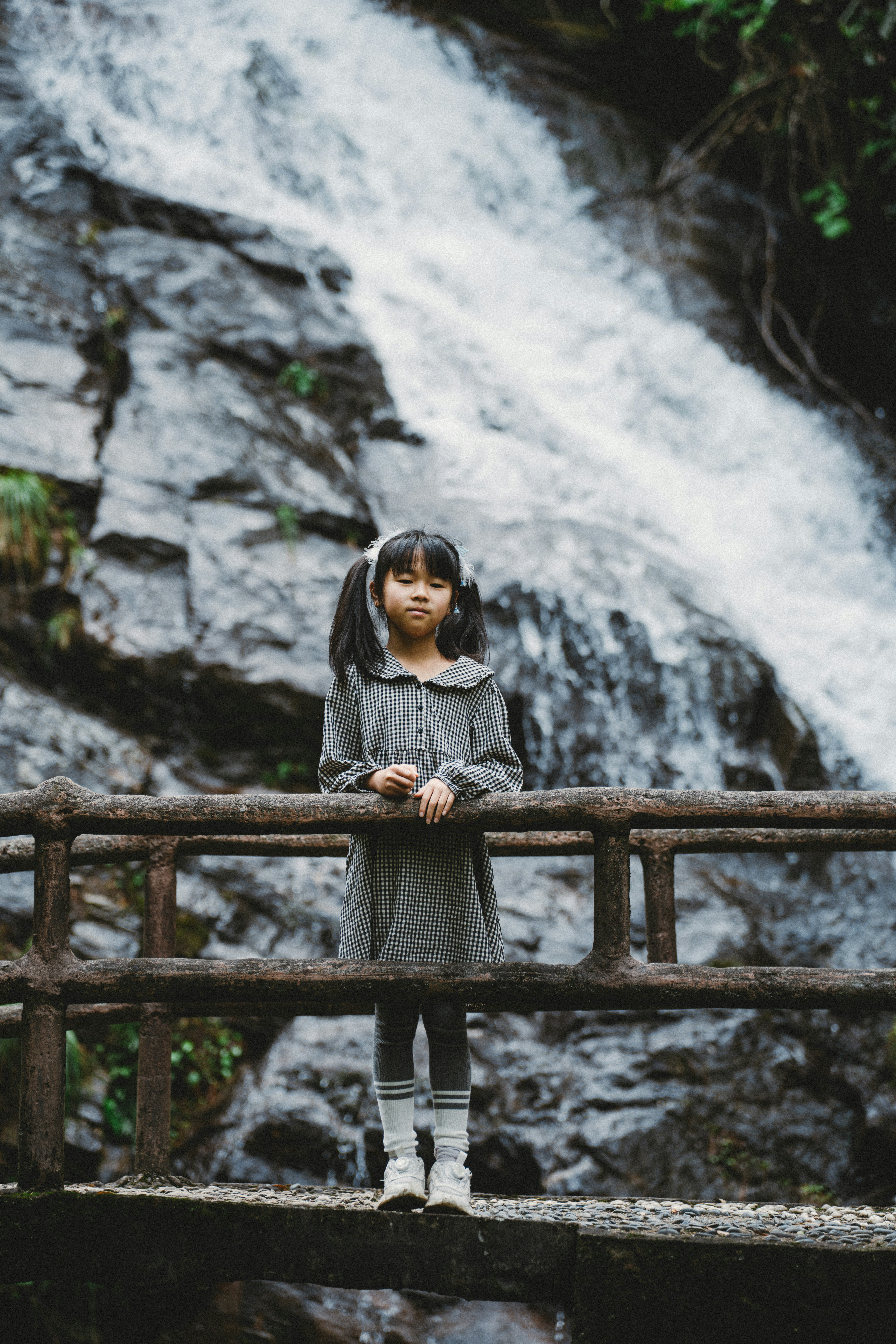 Girl on the Riverside Bridge Beneath a Cascade