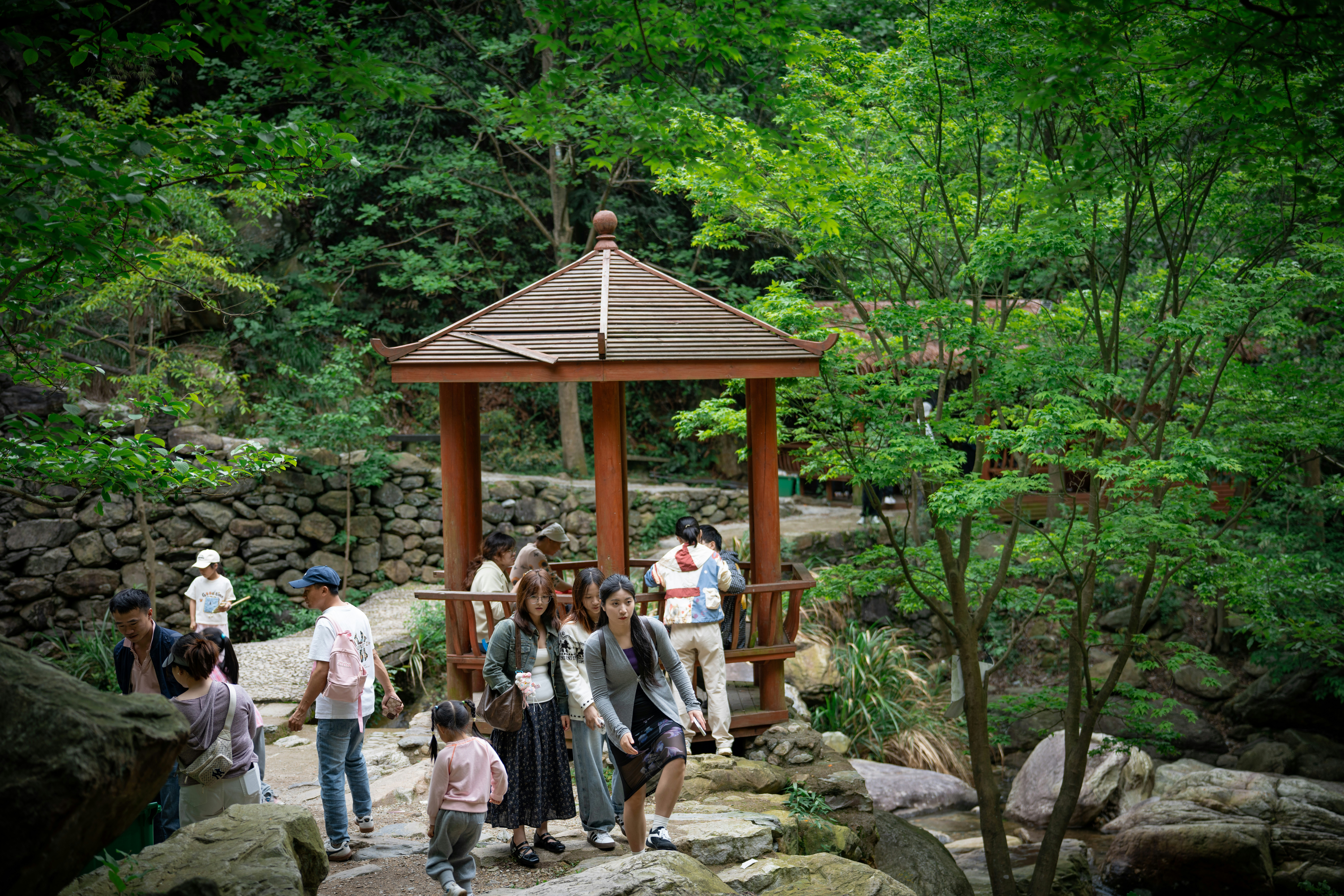 Family at a Wooden Gazebo Amid a Forested Stream