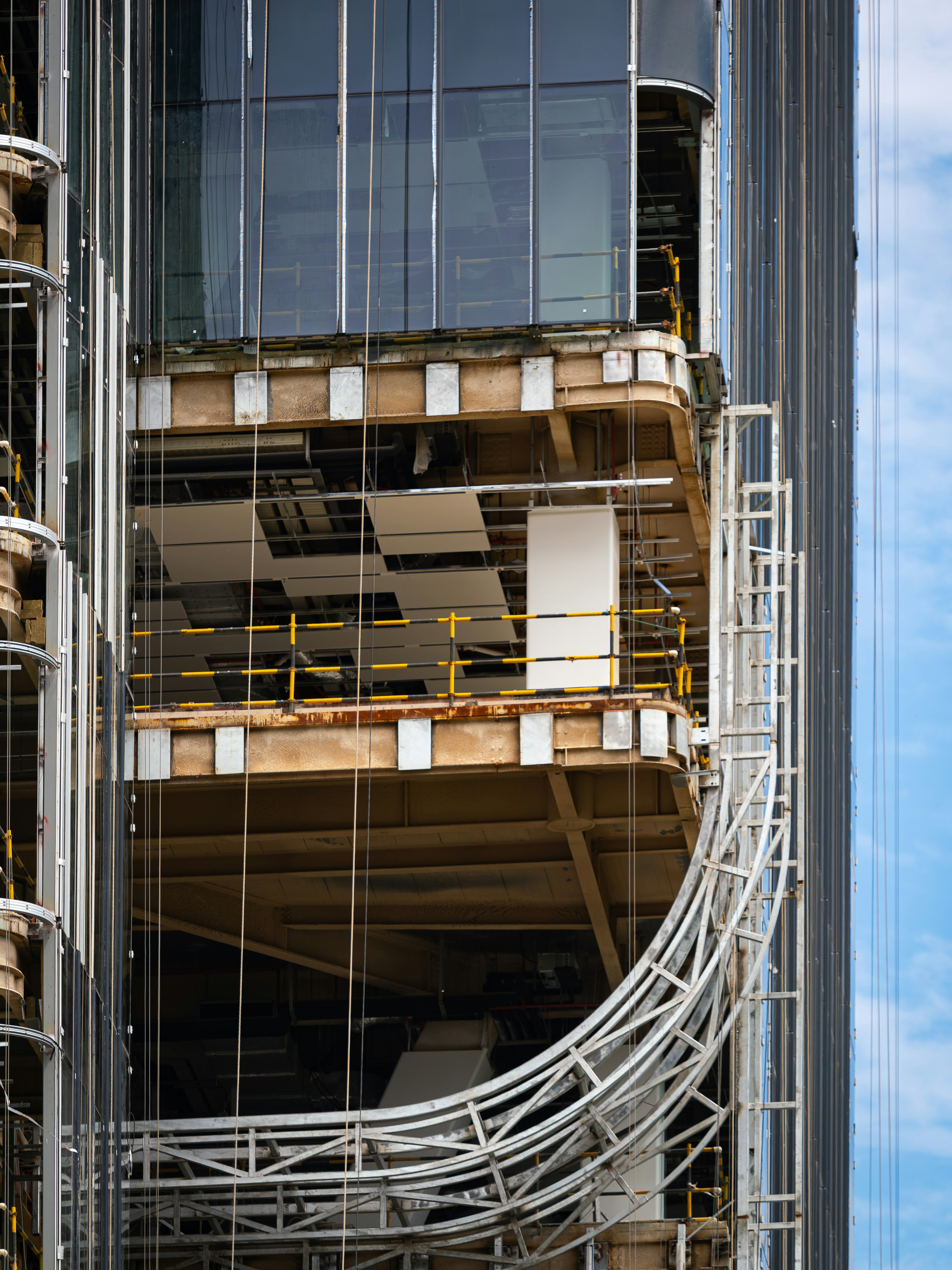 Modern building under construction with glass and metal facade.