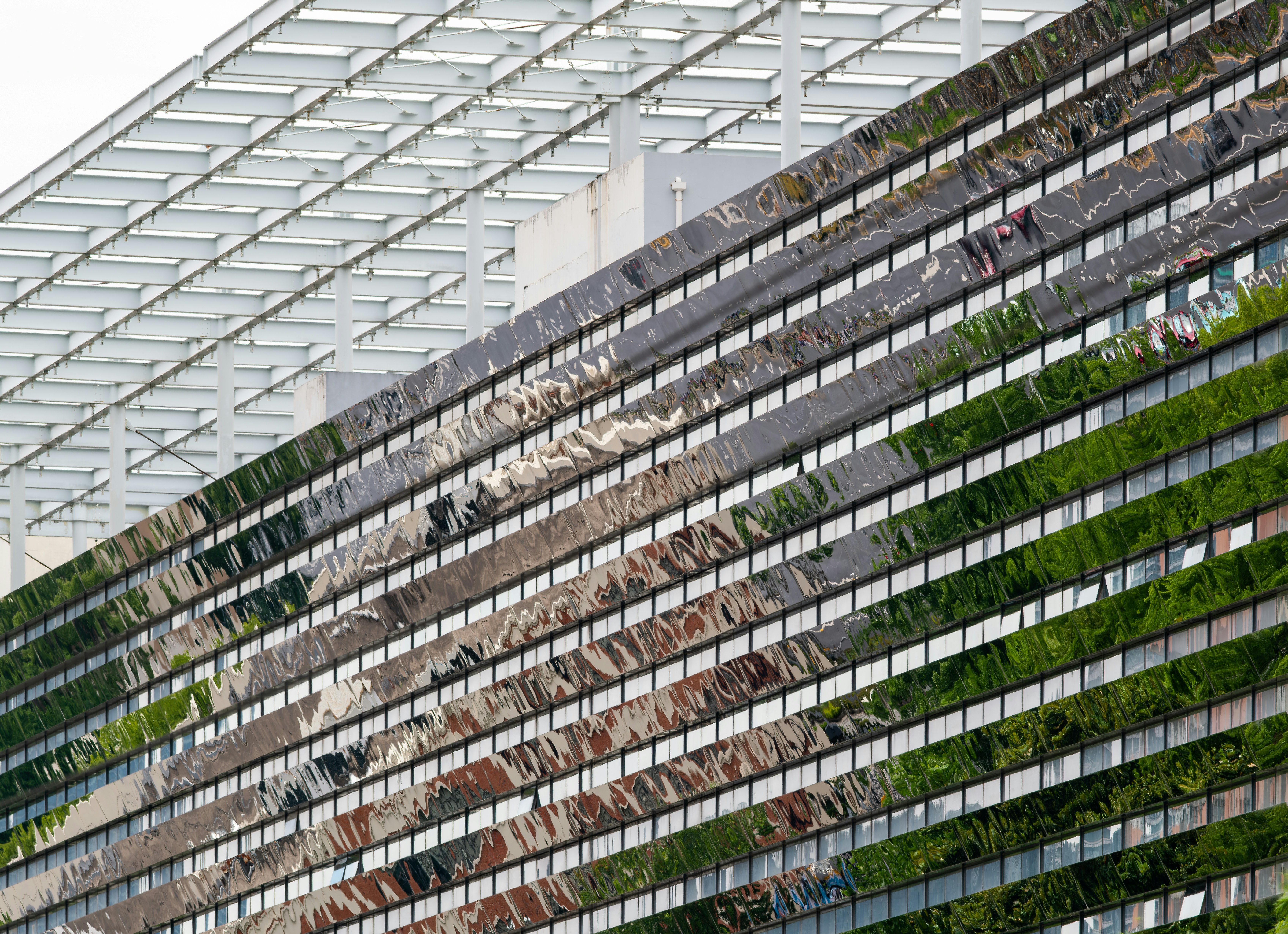 Modern building with reflective windows and a glass roof structure.