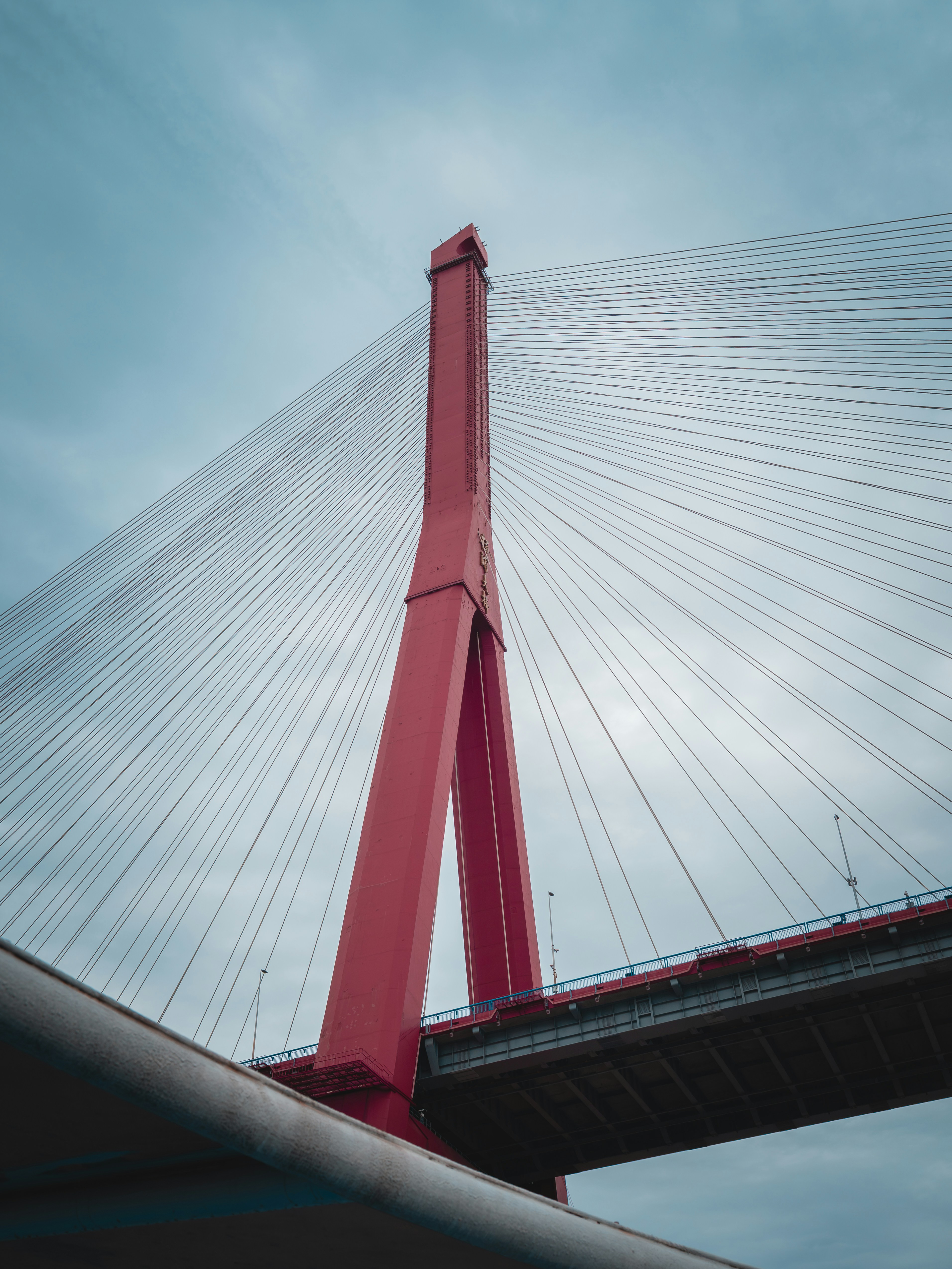Rising Red Cable-Stayed Tower Framed Against Sky