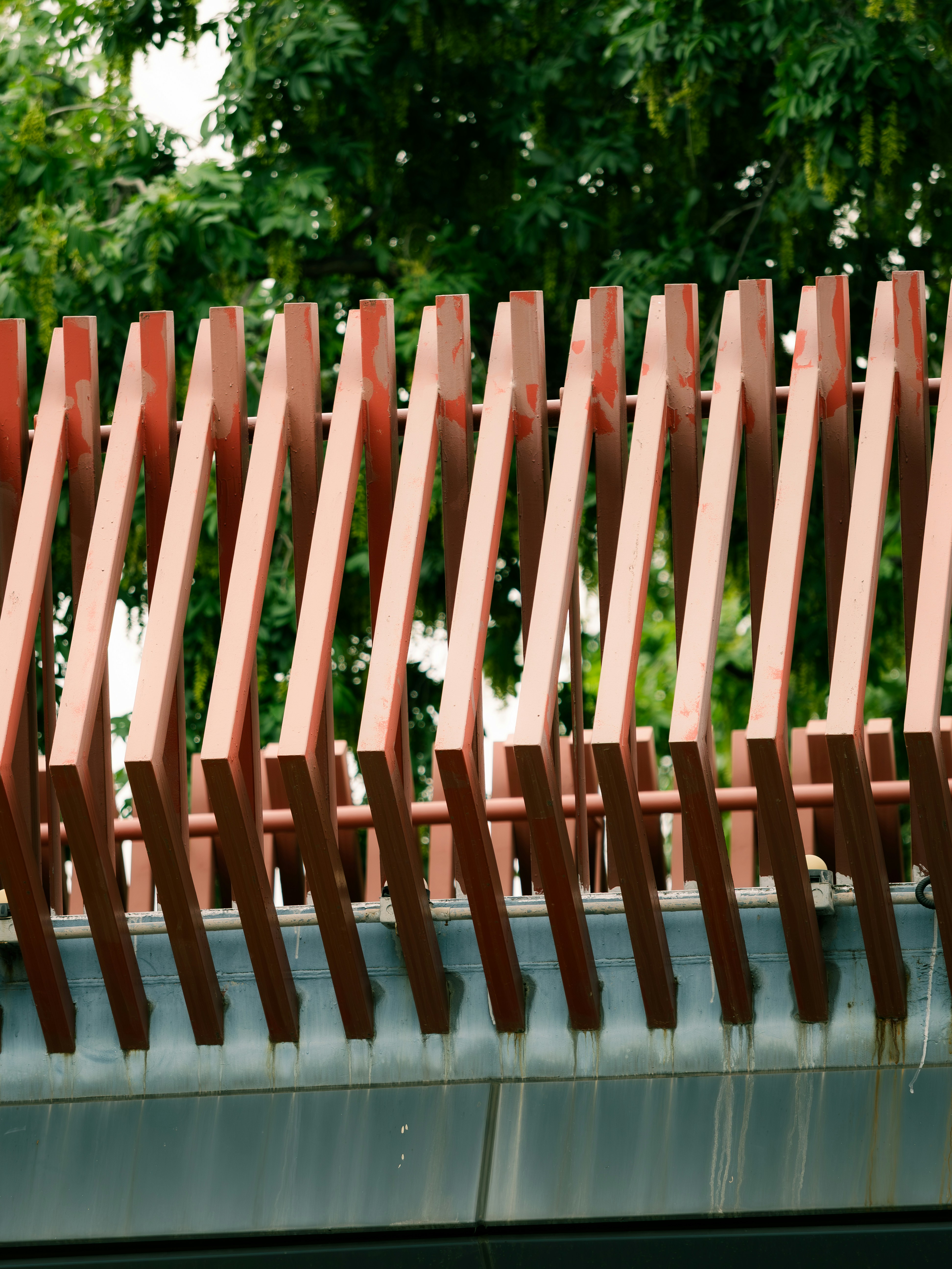 Orange Fence Rhythms over a Glassy, Reflected Rail