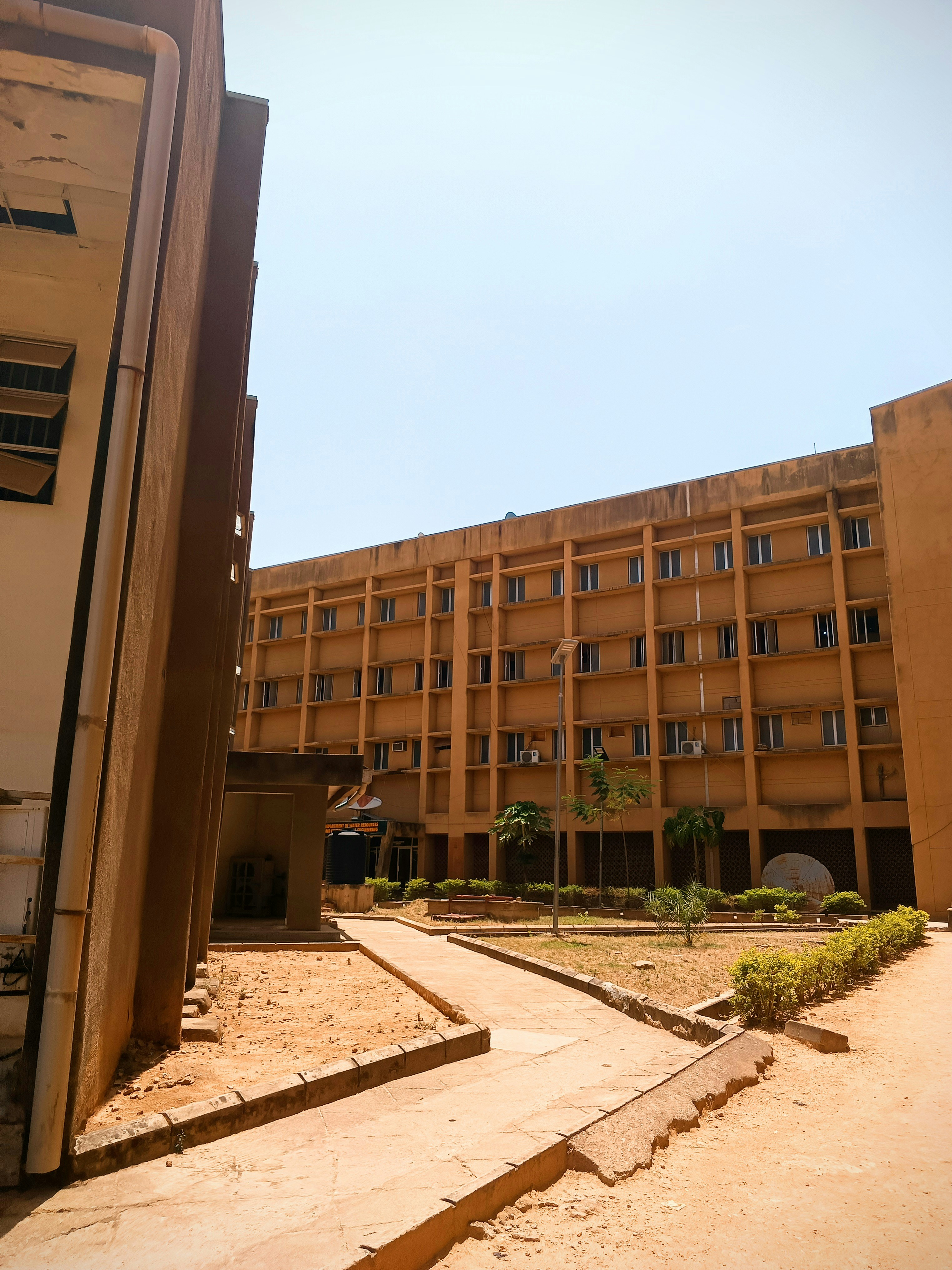Large orange building with many windows and a courtyard.