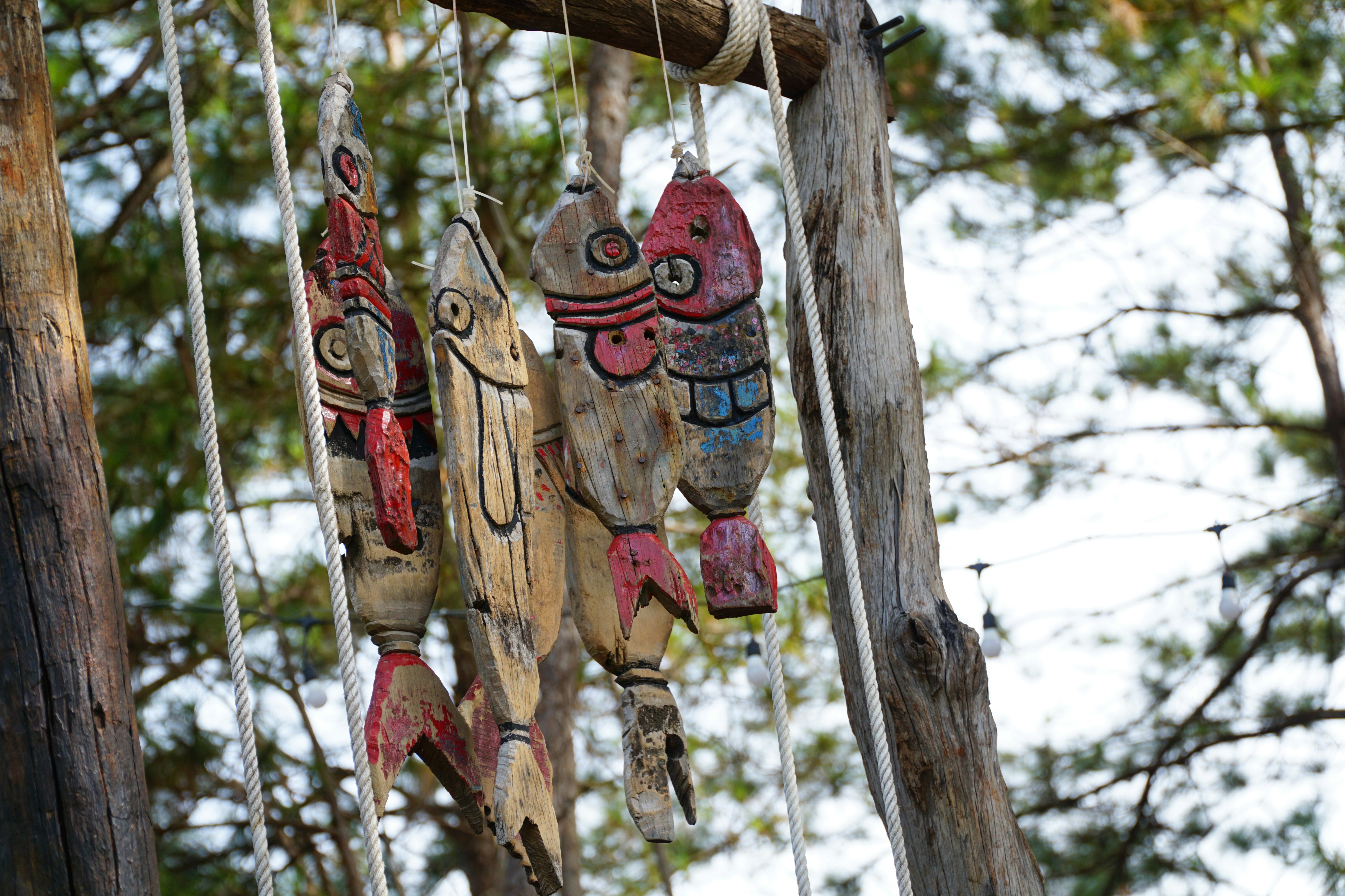 Weathered fish-carvings on a rustic ropes and timber frame