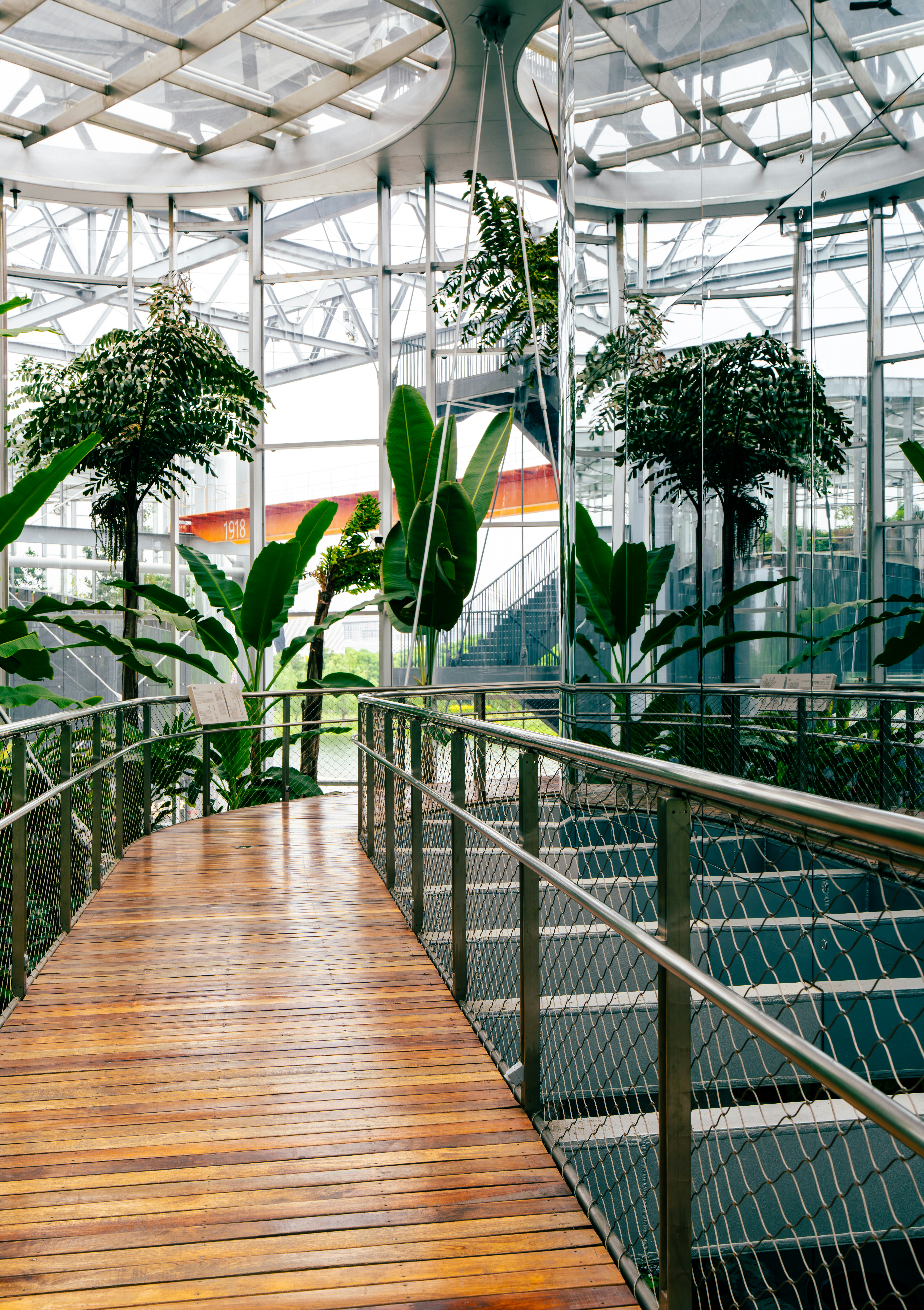 Suspended Atrium Walkway Leading to Lush Vertical Garden