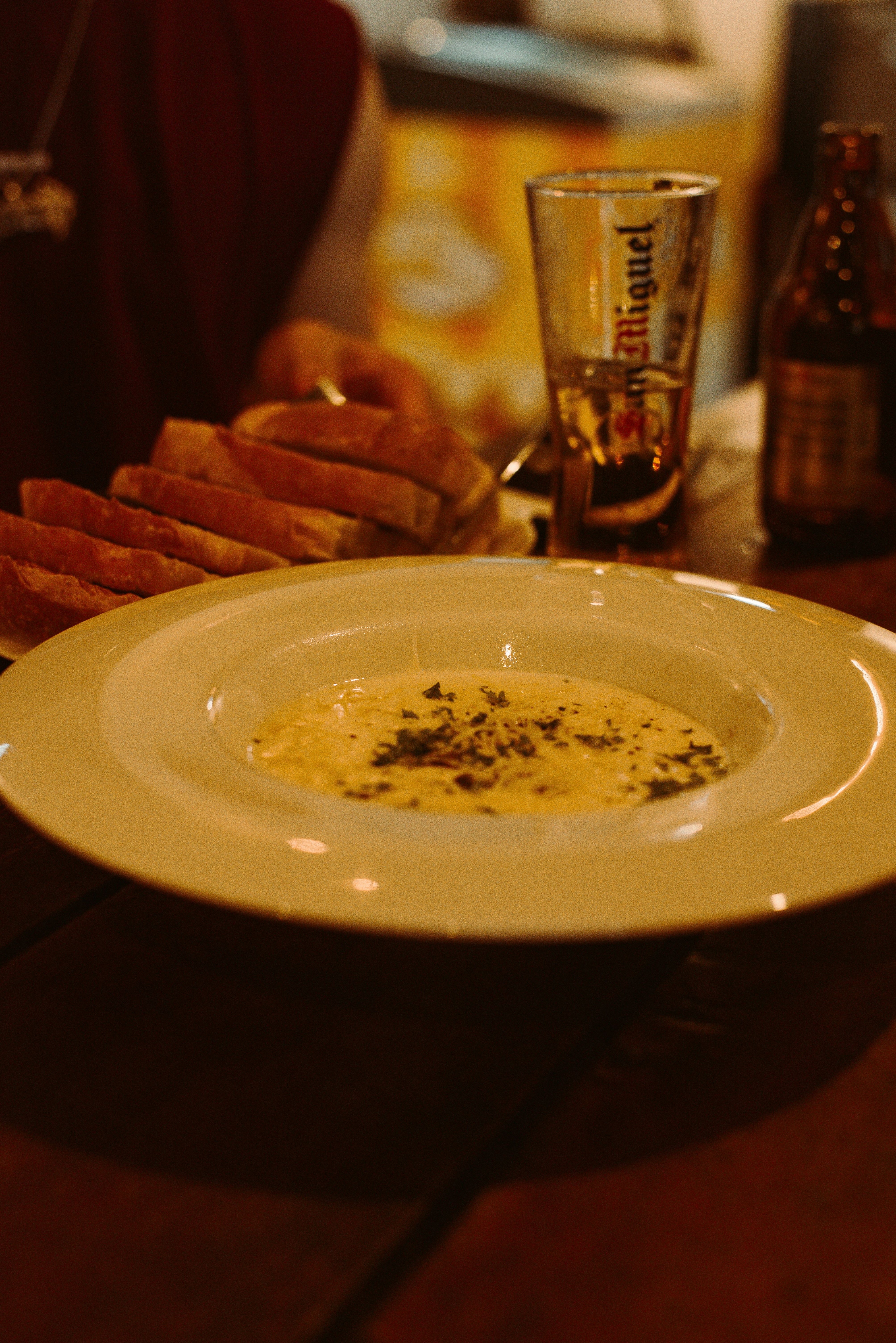 Creamy soup in a rustic setting with bread and a glass of beer