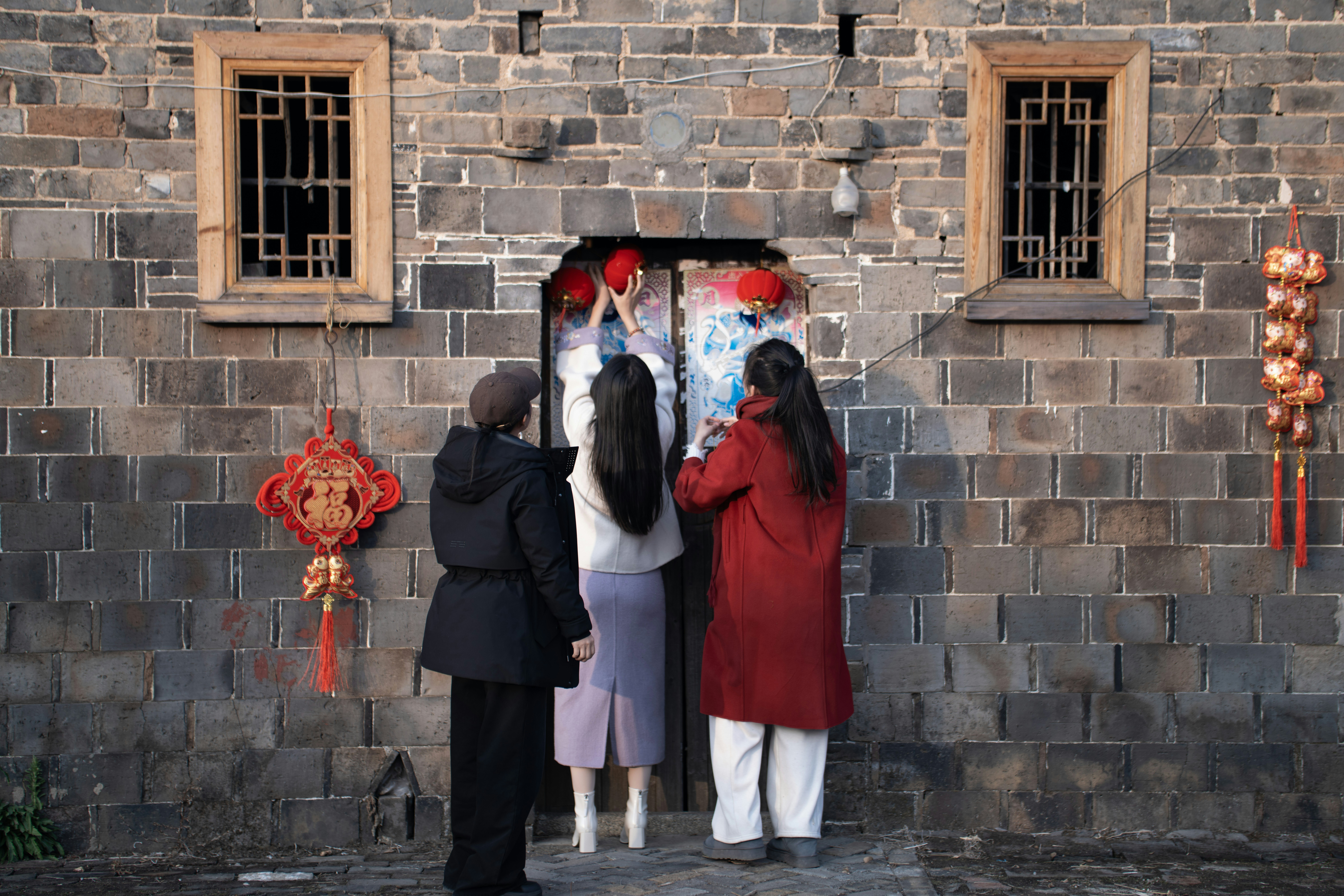 Three Women in Front of a Historic Doorway Reach into a Mystery