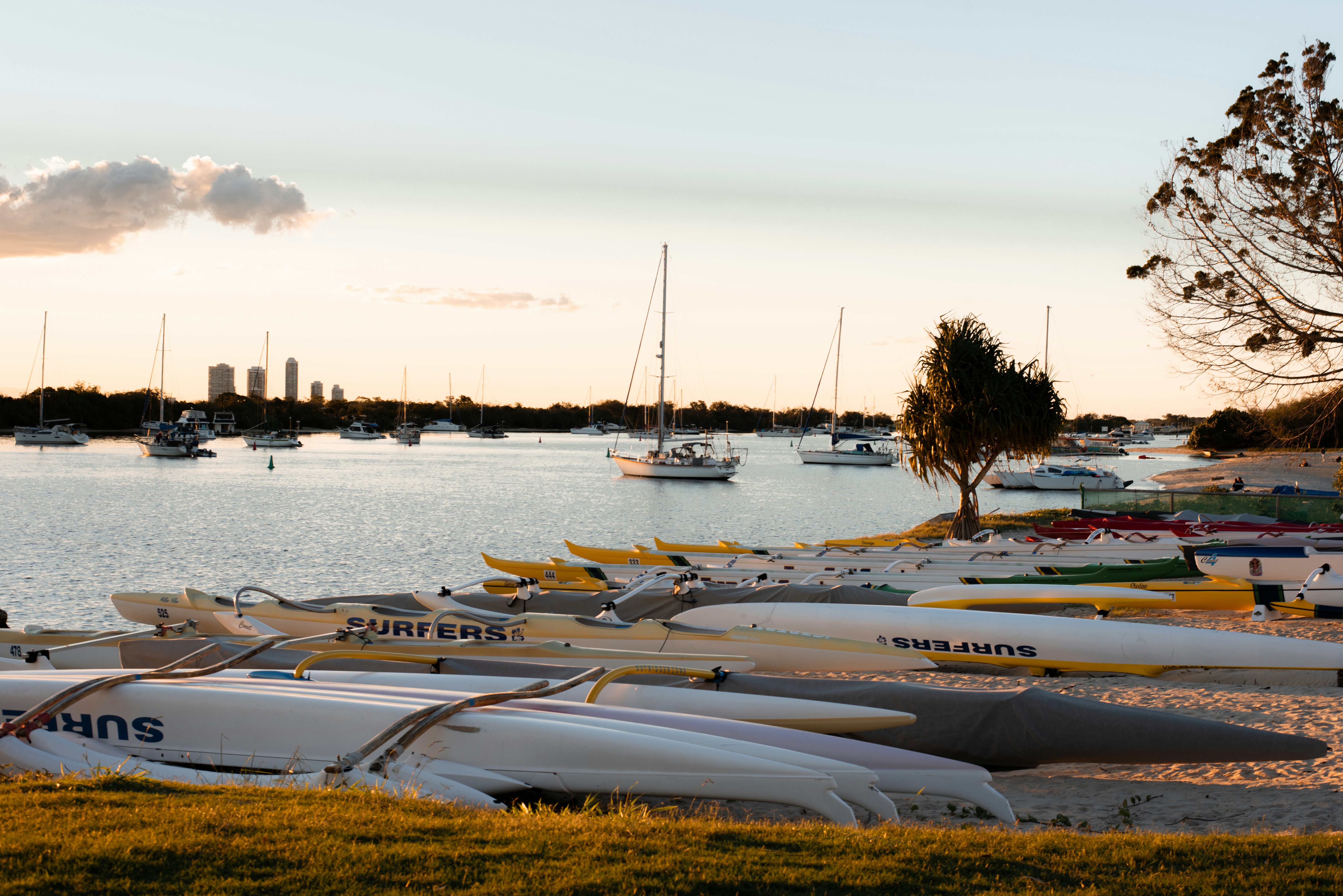 Row of Kayak hulls Resting Along the Shore at Sunset
