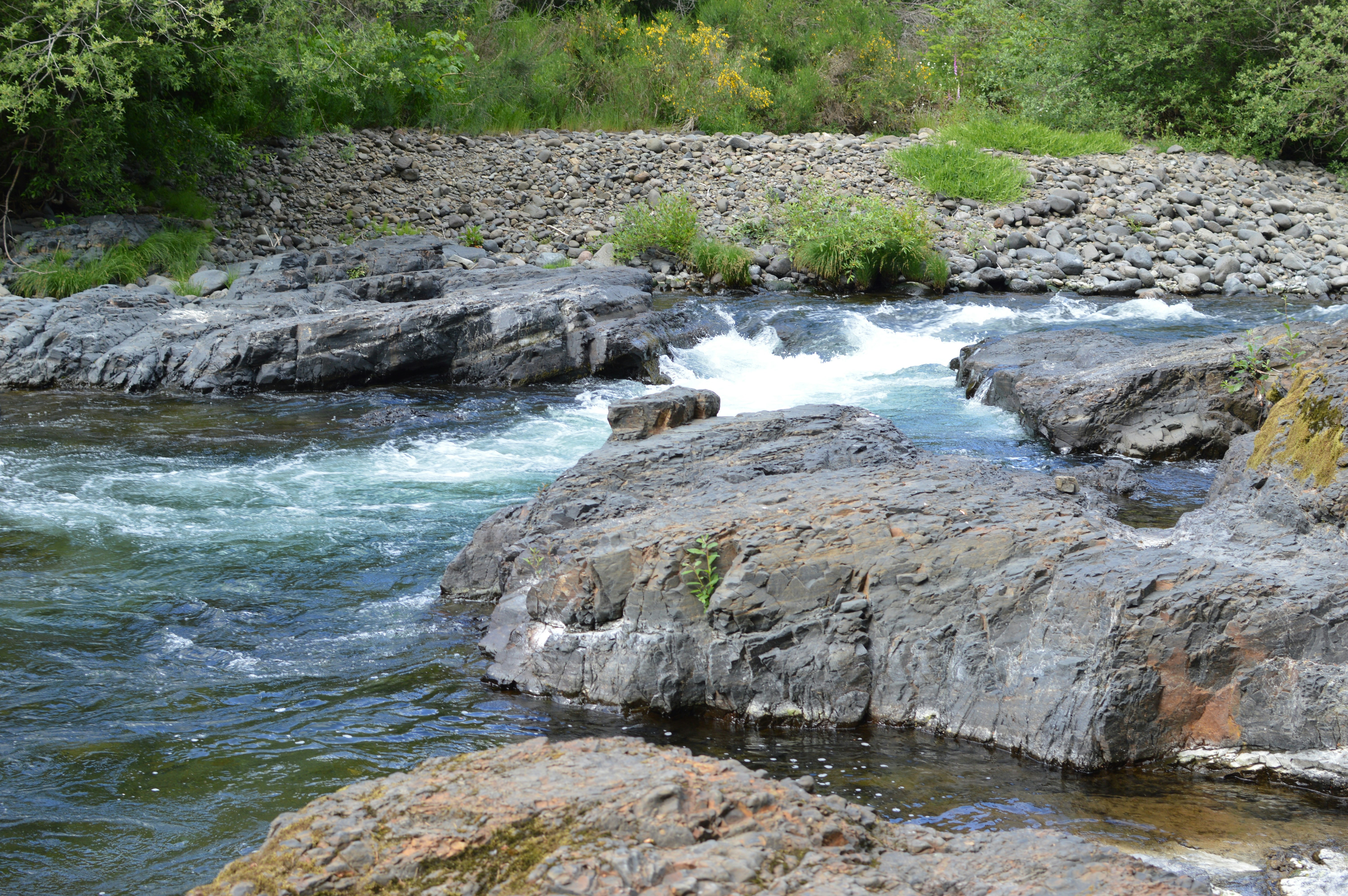 Rugged River Crossing: Sunlit Granite and Moving Waters