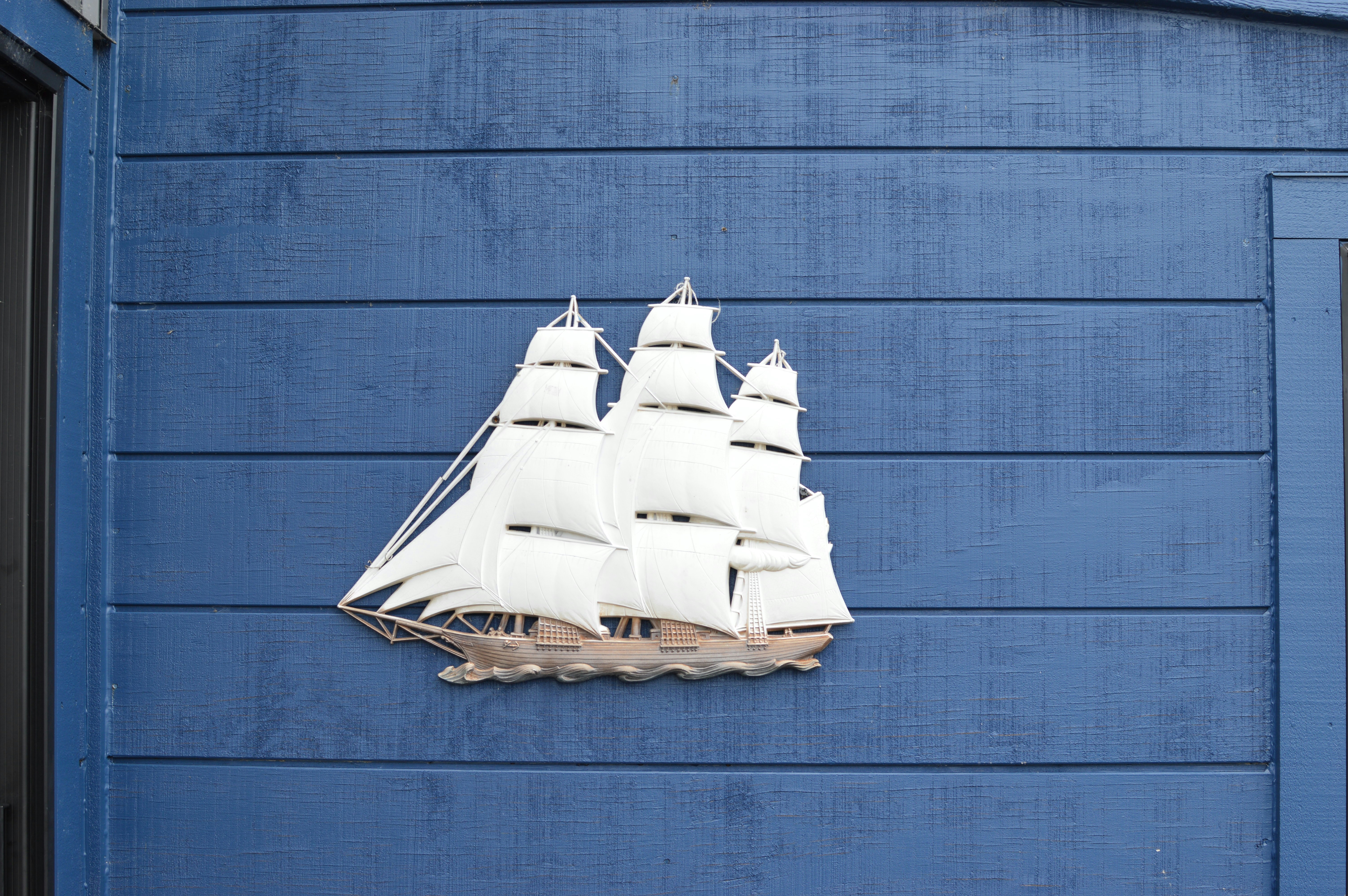 Sailing on Blue Planks: A White Ship Emerges from the Wall