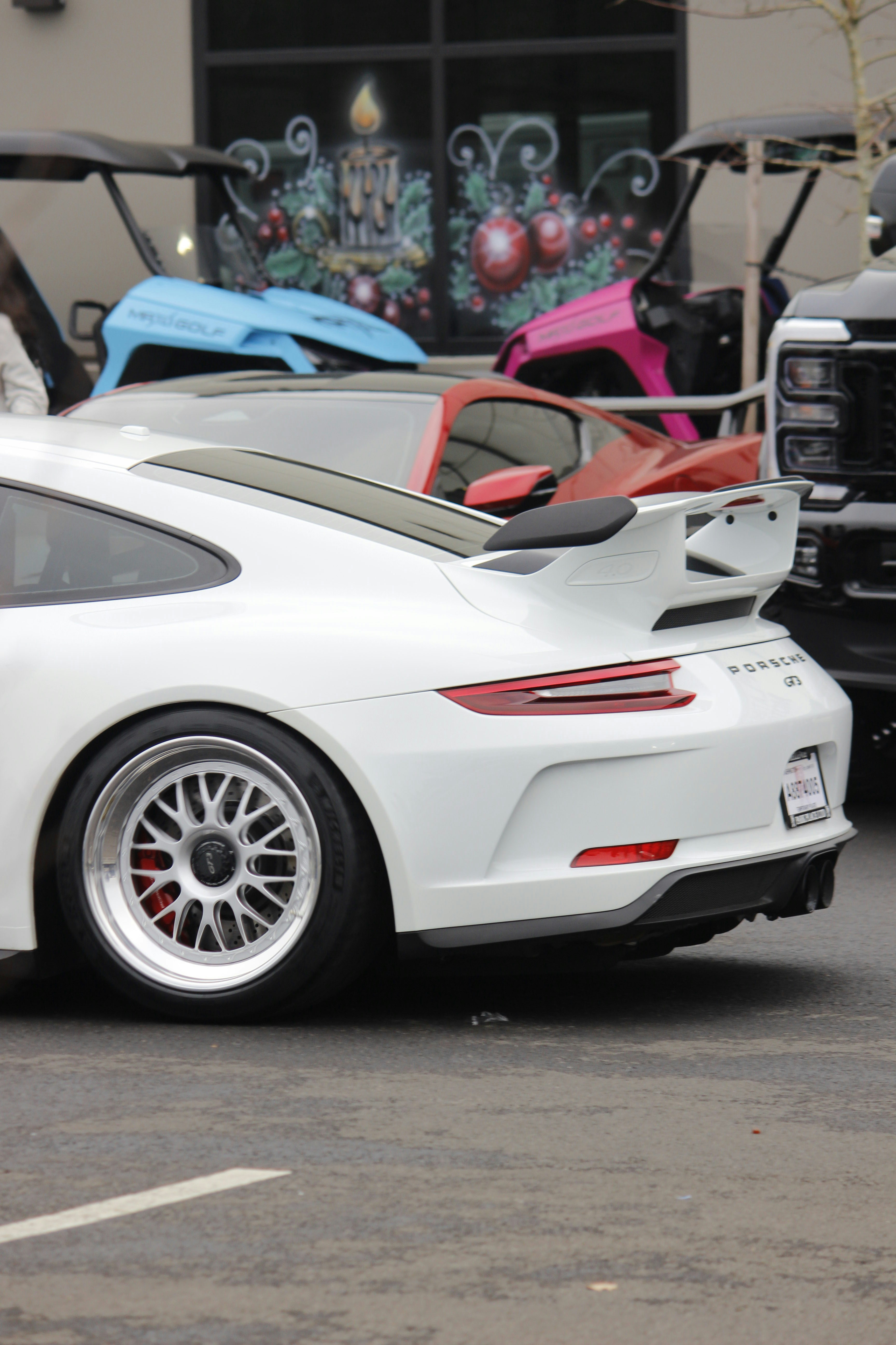 Rear Quarter of a White Porsche GT with Aggressive Wing in a Car Show