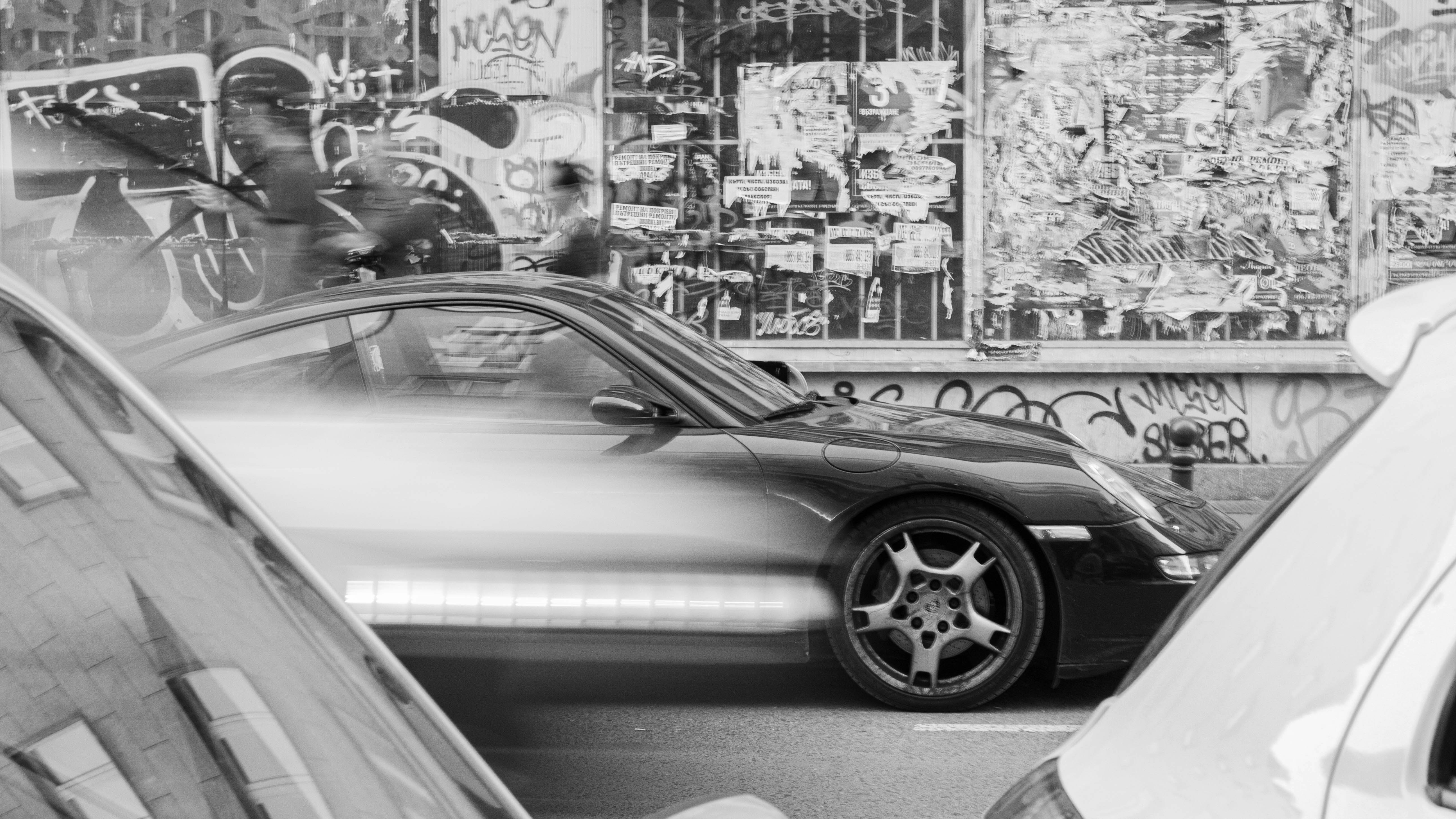 Blurred Velocity: A Moving Car Streak Through Graffitied Streets