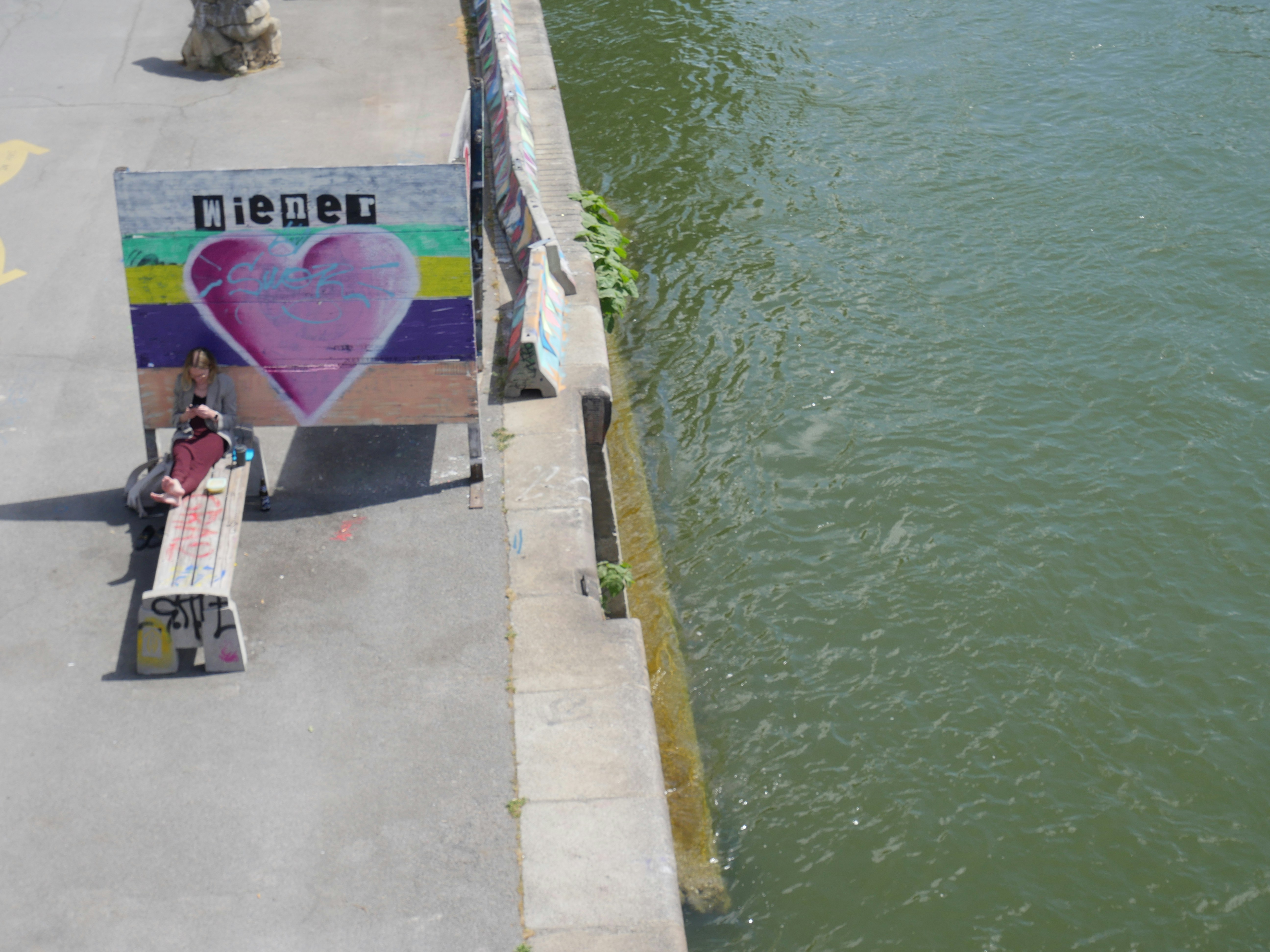 Heart mural by the water’s edge on a sunlit promenade