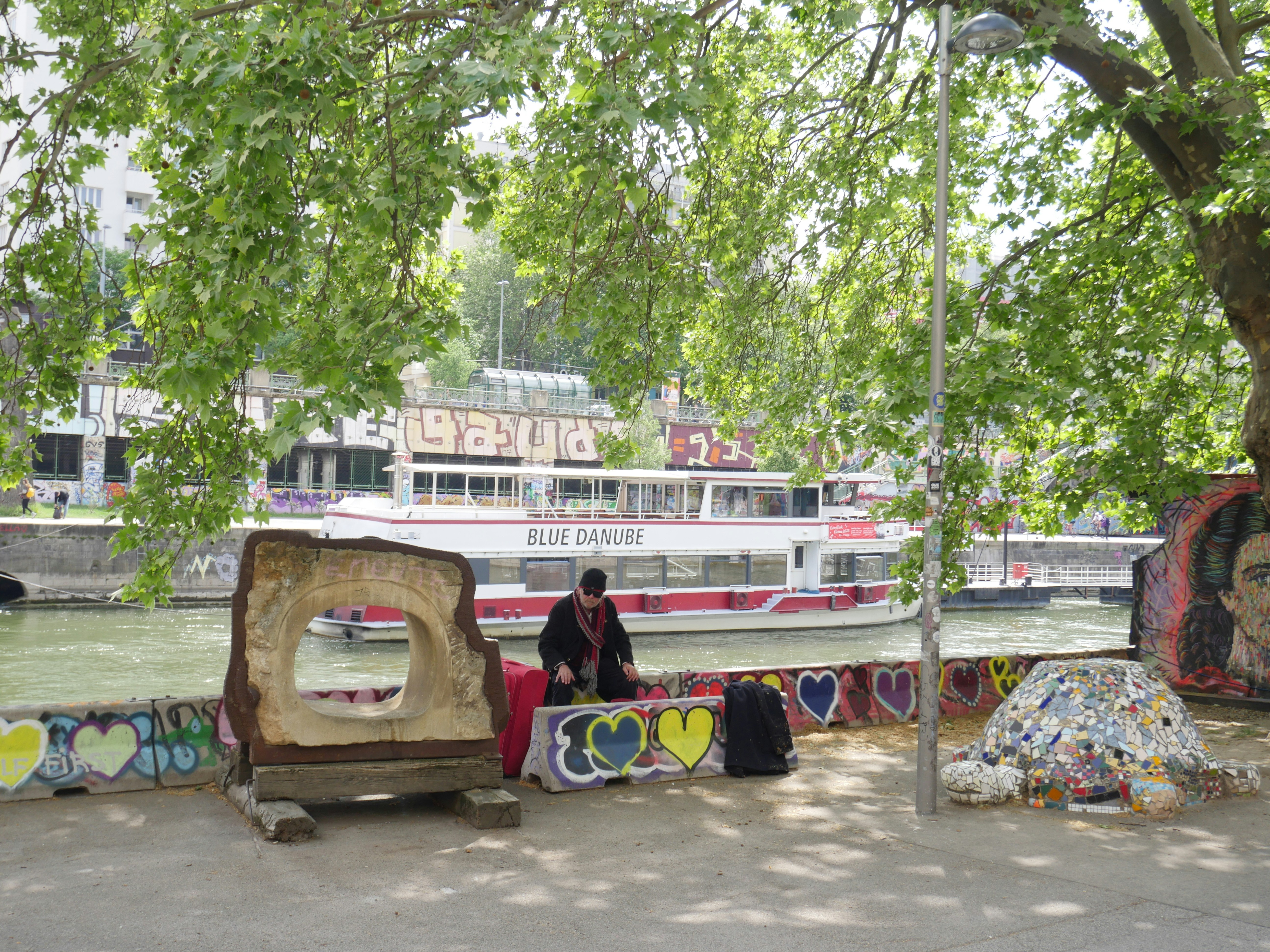 Portrait Under the Canopy: A Street Artist at the Riverfront
