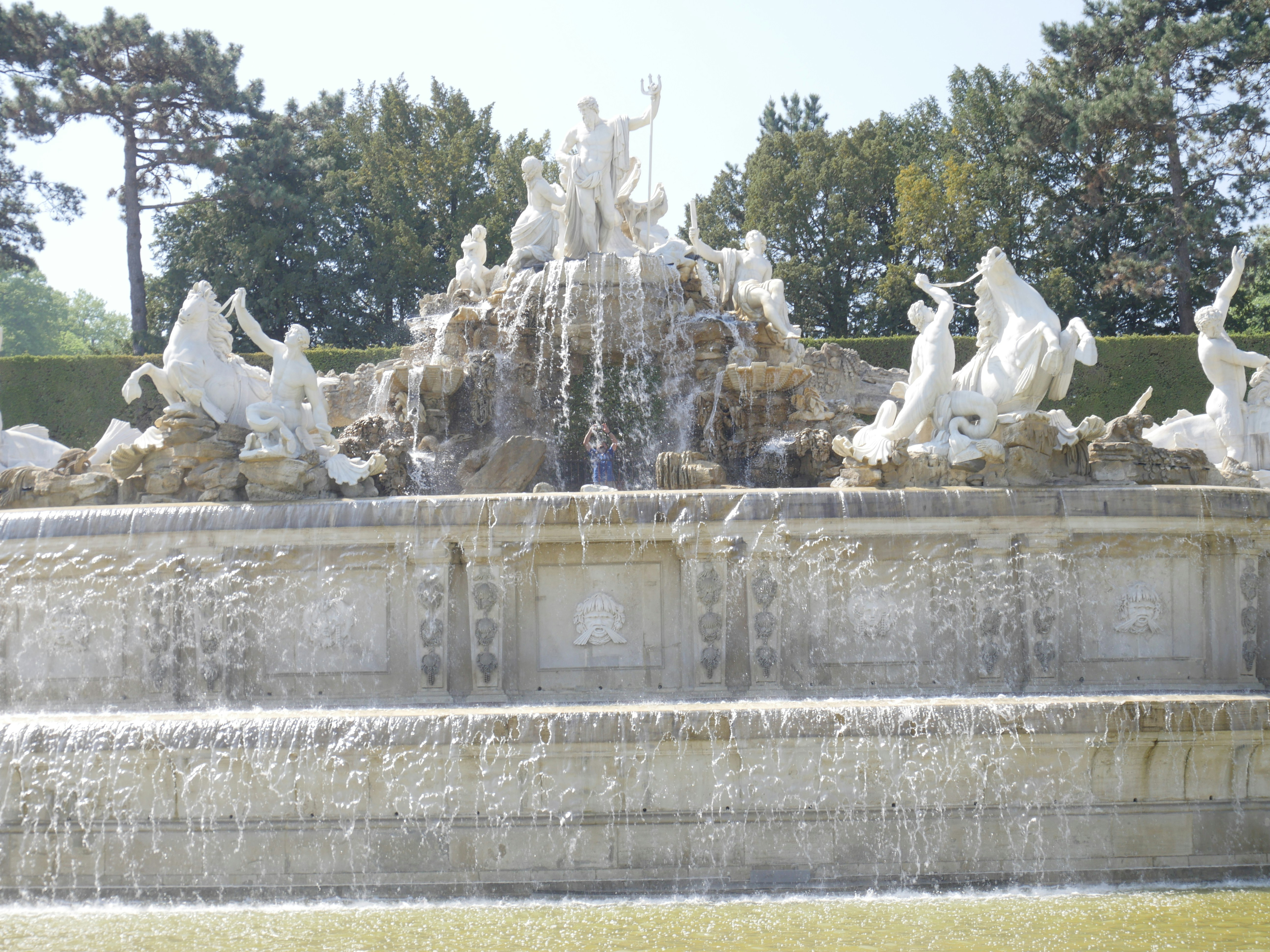 Cascade of Sculpted Graces: A Sunlit Fountain Portrait