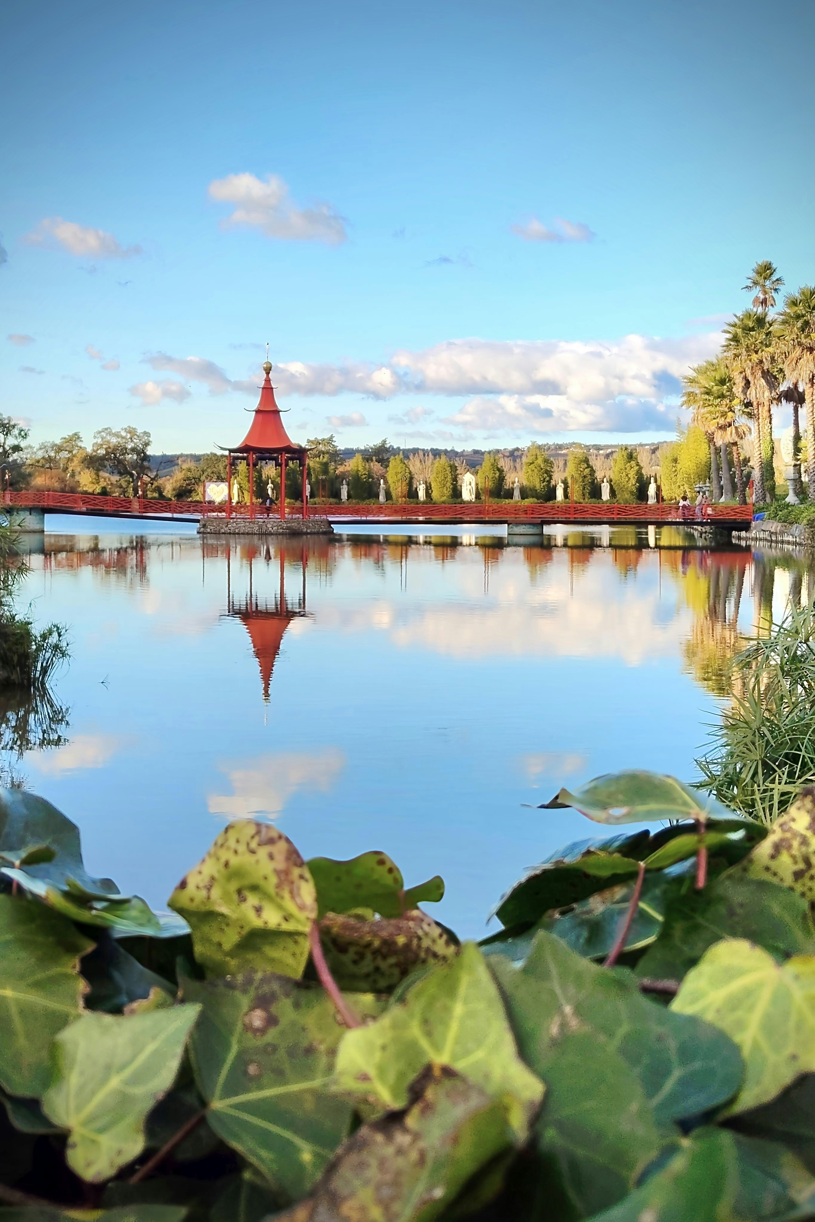 Red pagoda over still water: a tranquil park scene mirrored by a calm lake