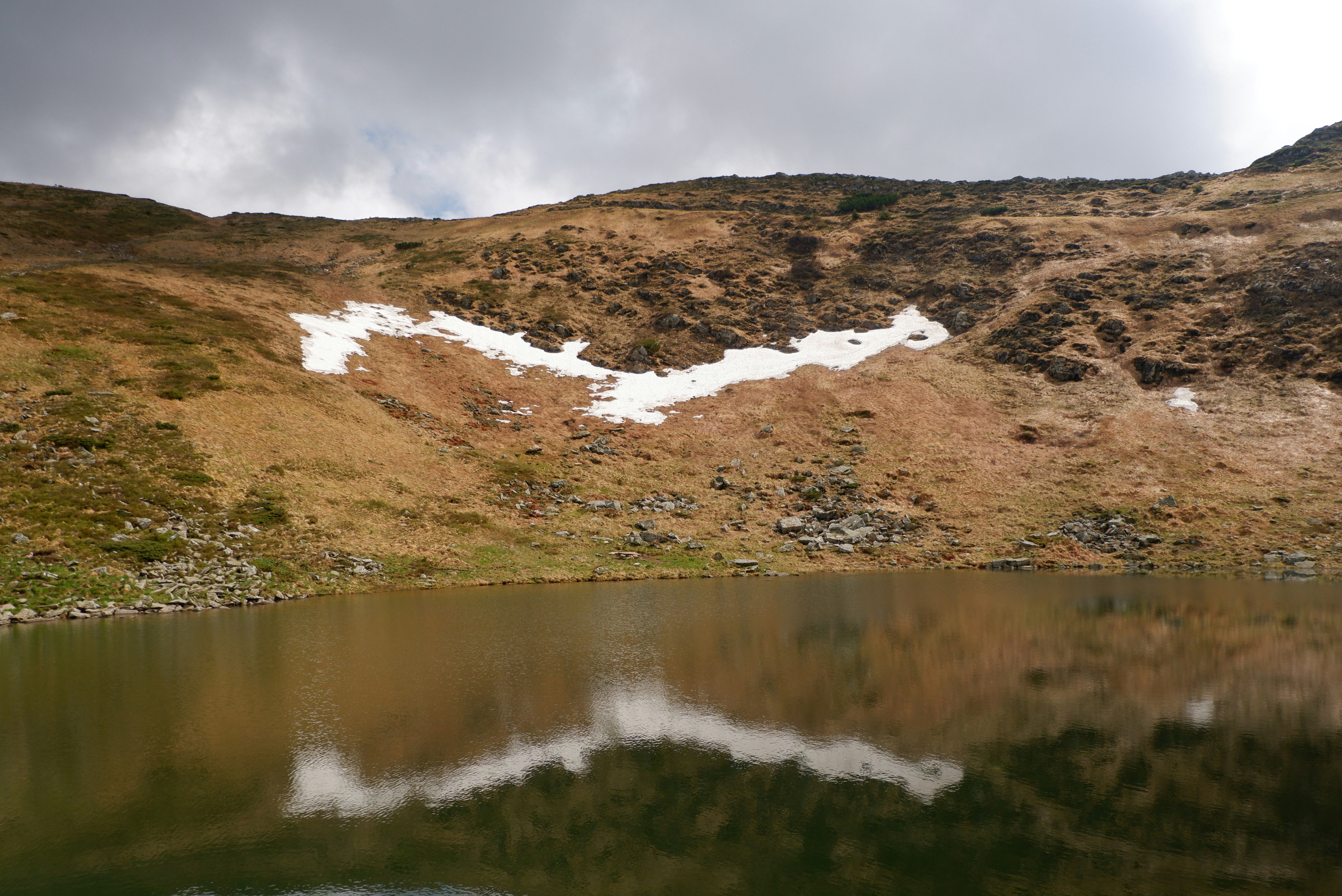 Quiet Alpine Mirror: Snow‑touched Ridge Reflecting in Still Waters