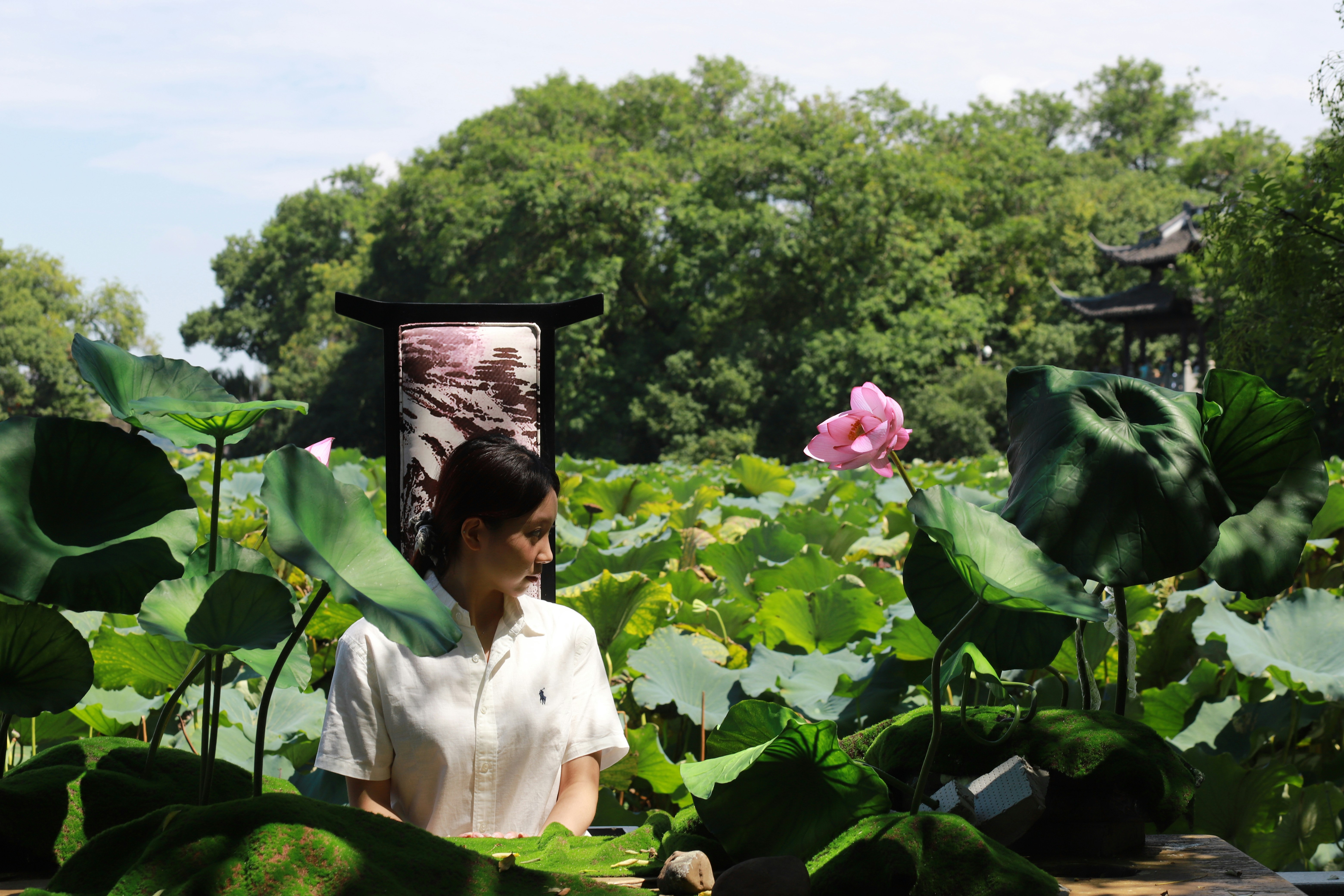 Portrait among lotus and screens: a calm moment in the garden