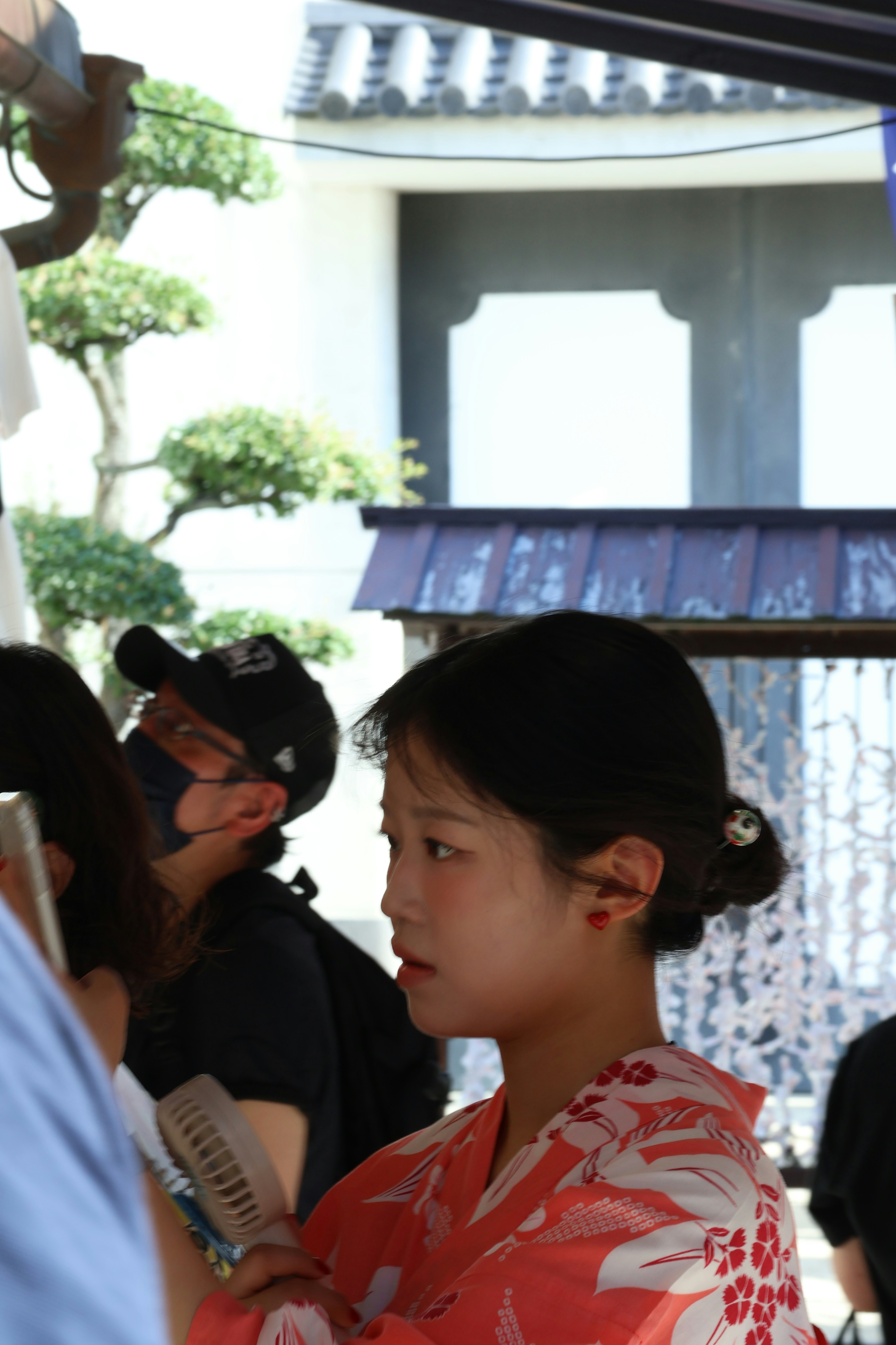 Portrait in Traditional Red Kimono Amid Busy Backdrop