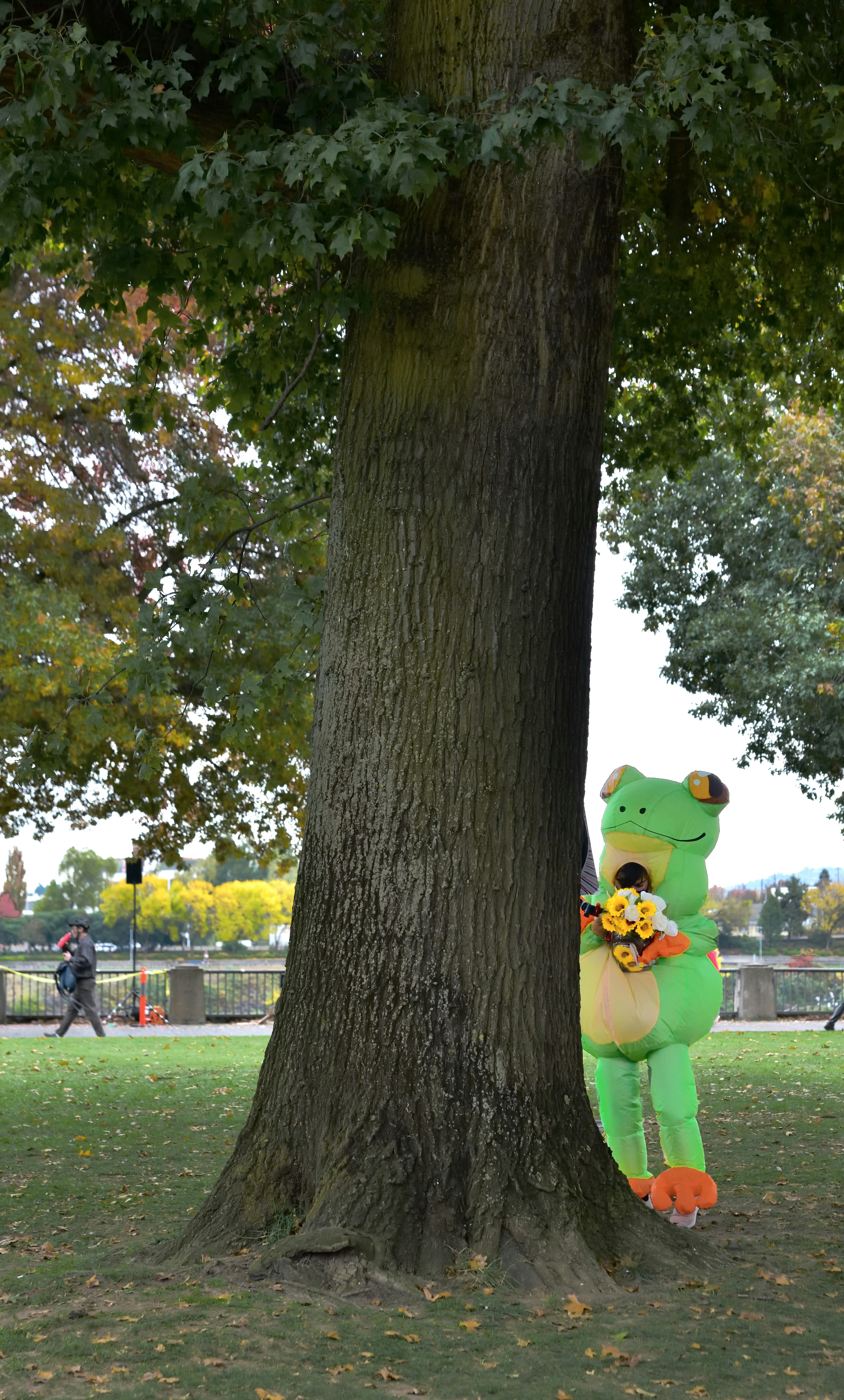 Green Giant by the Riverside: A Mascot Portrait Amid Autumn Trees