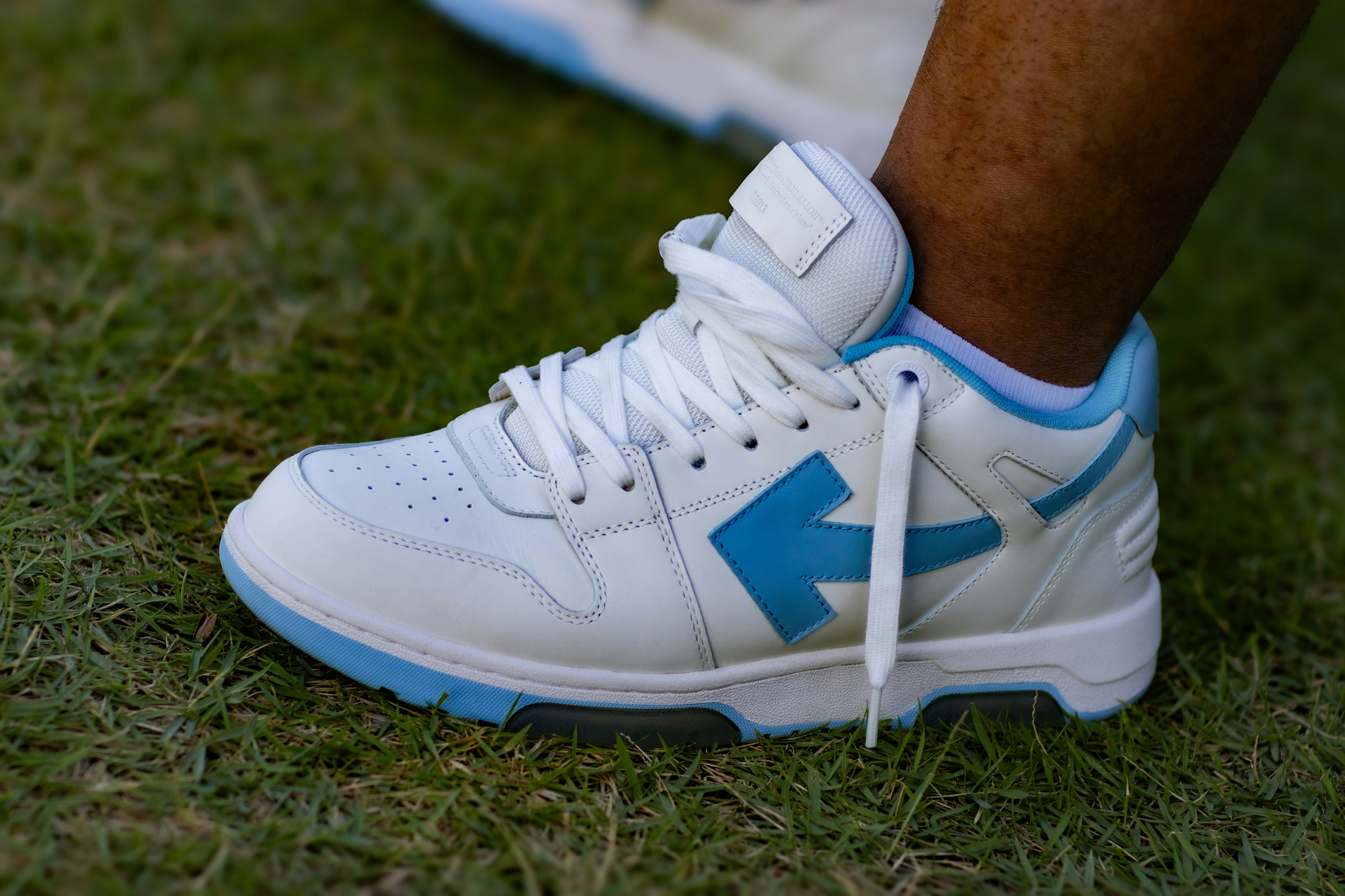 Sprint at the Patch: A White and Blue Sneaker Ready to Hit Grass