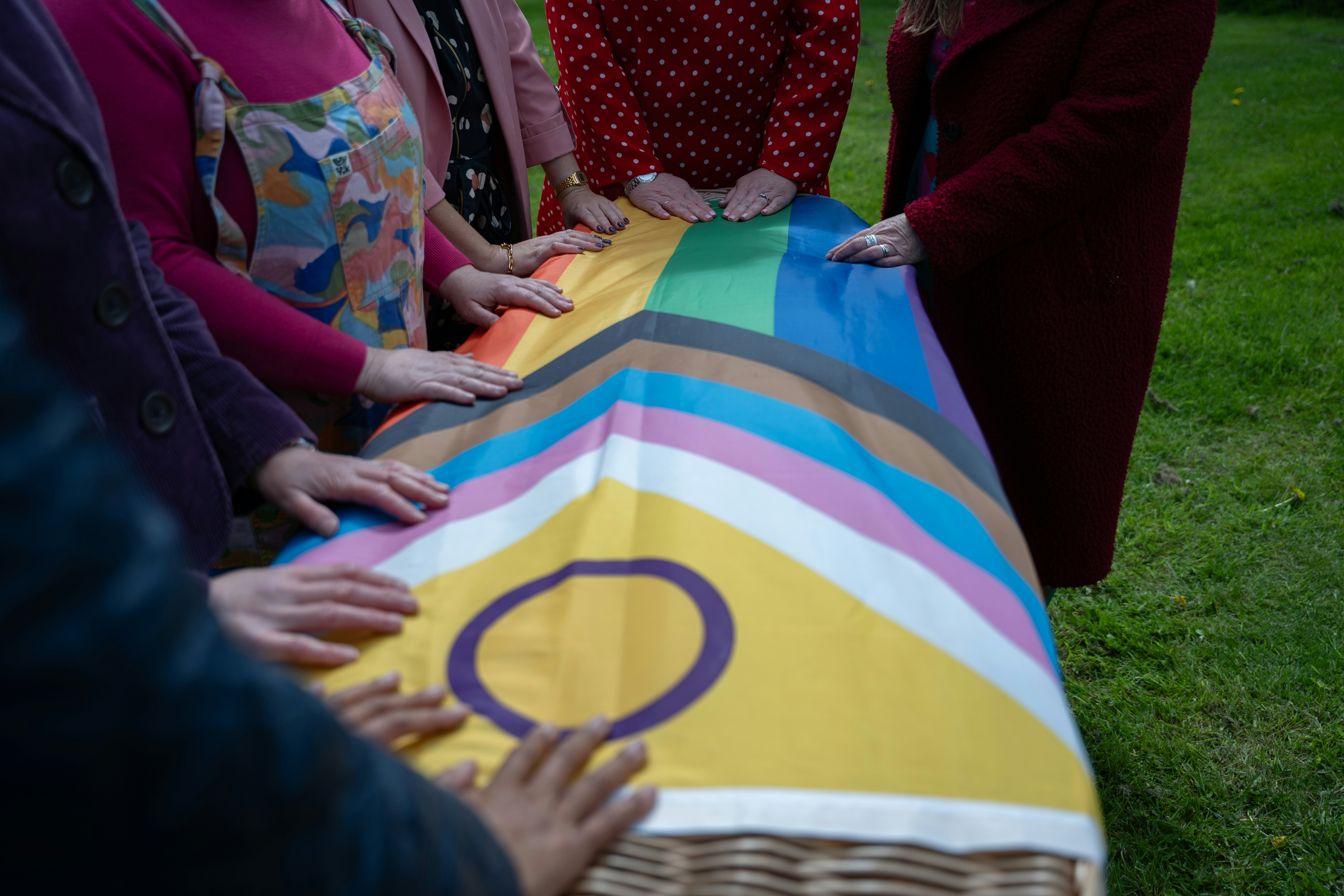 Hands Gather Around a Vibrant Shared Banner in Outdoor Circle