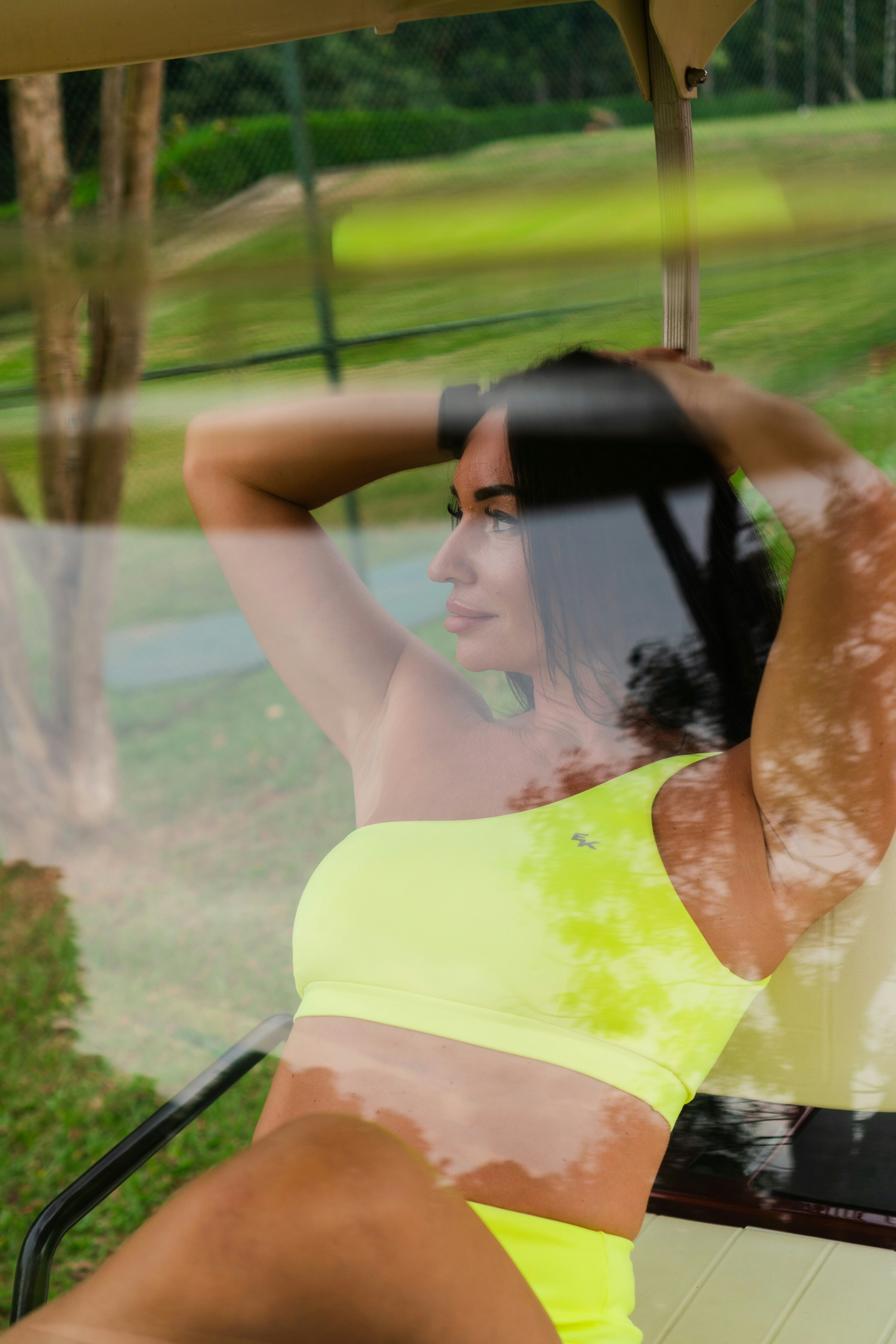 Neon-yellow athletic silhouette framed by glass and greenery