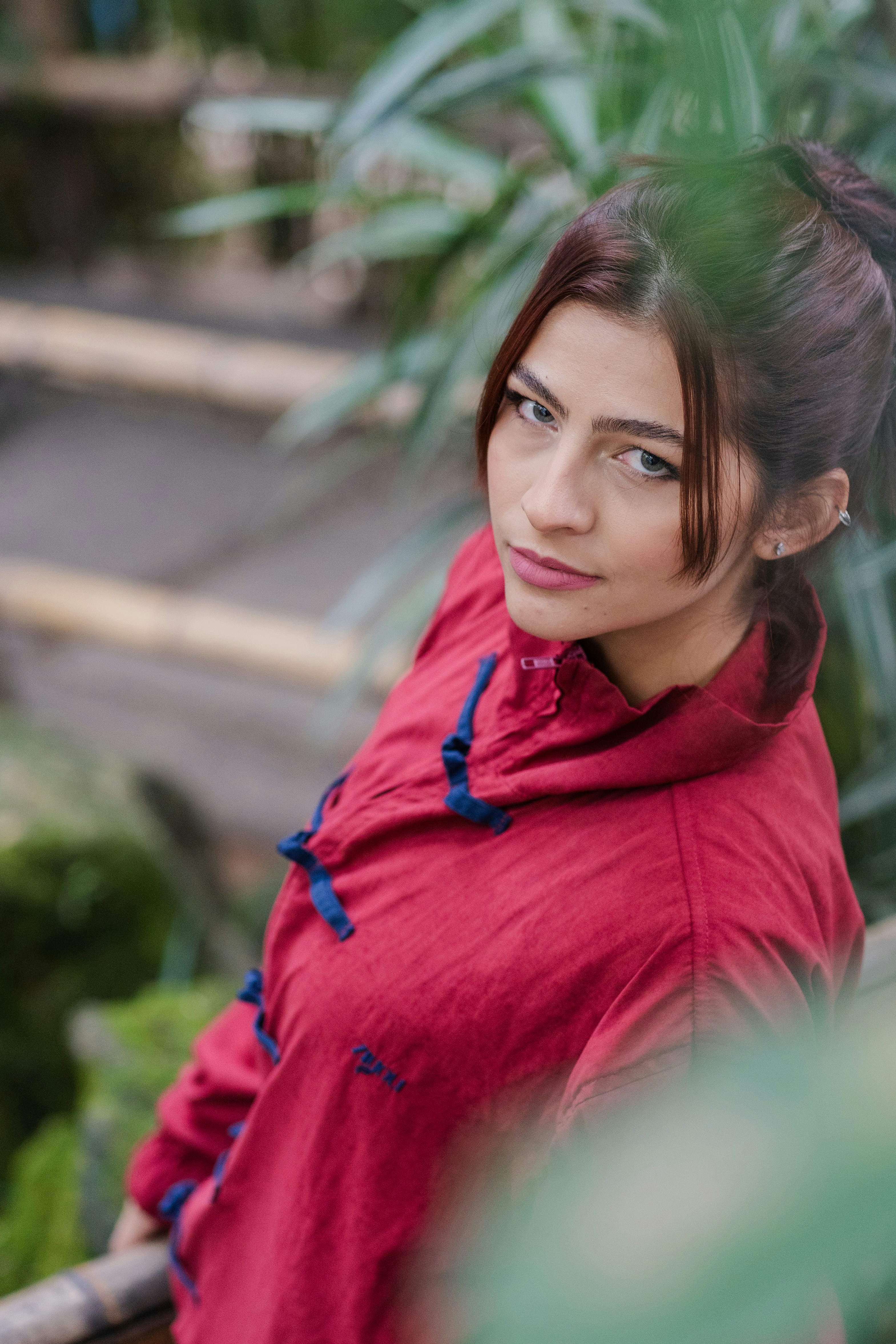 Crimson Jacket, Quiet Gaze: Portrait Behind Green Veils