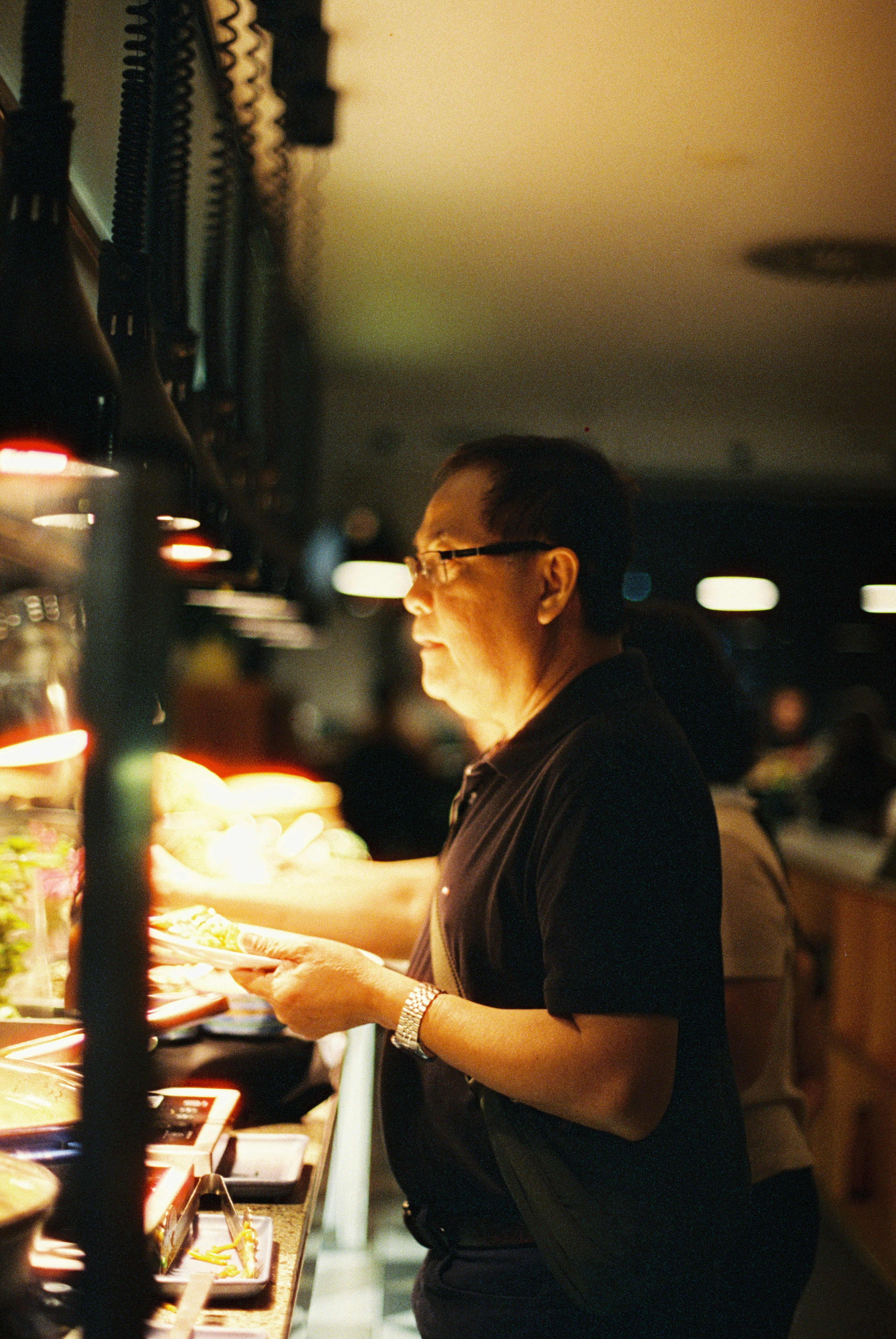Man selecting food from a buffet line.