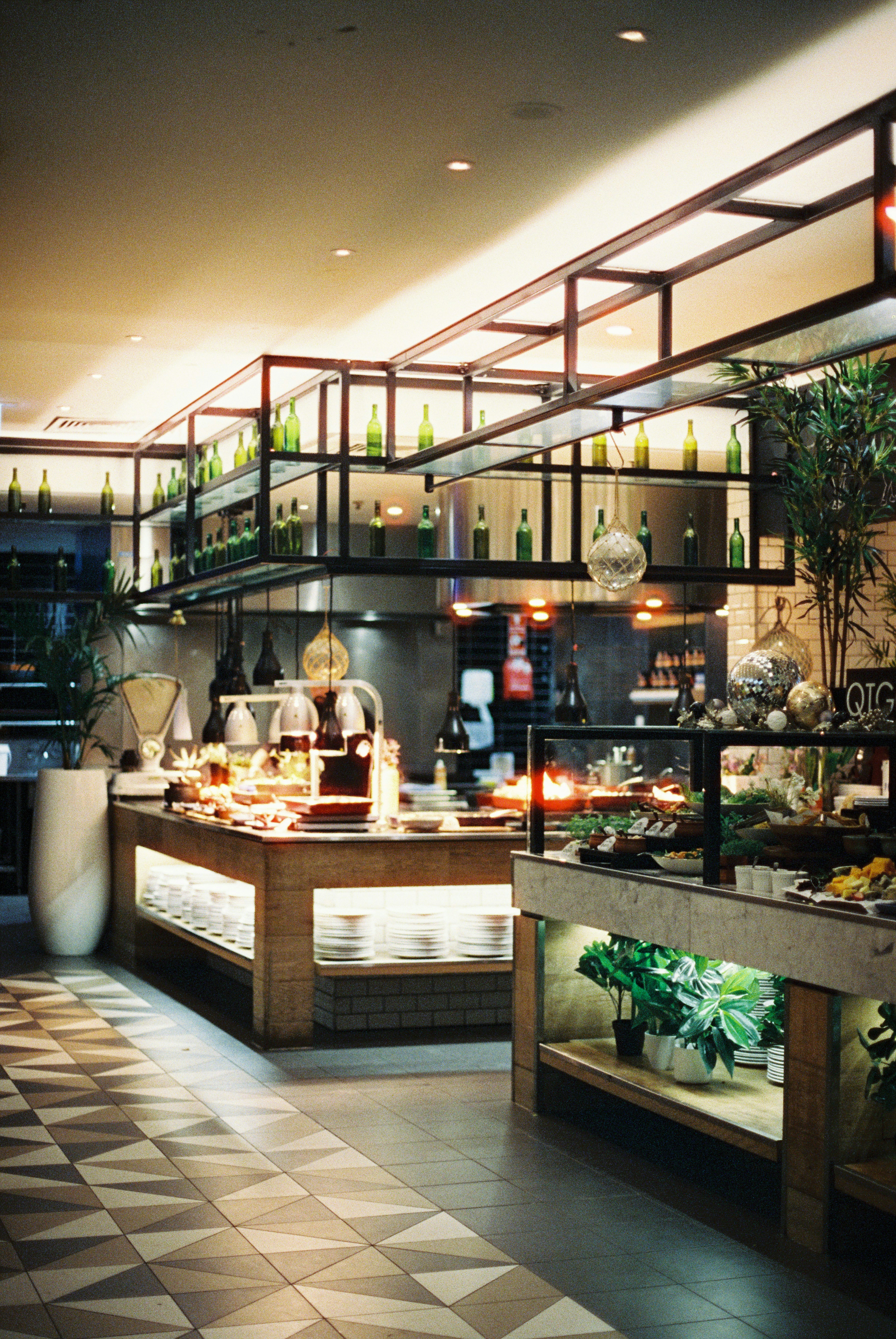 Luminous Cafeteria Corridor: Shelves of Bottles and Dessert Display