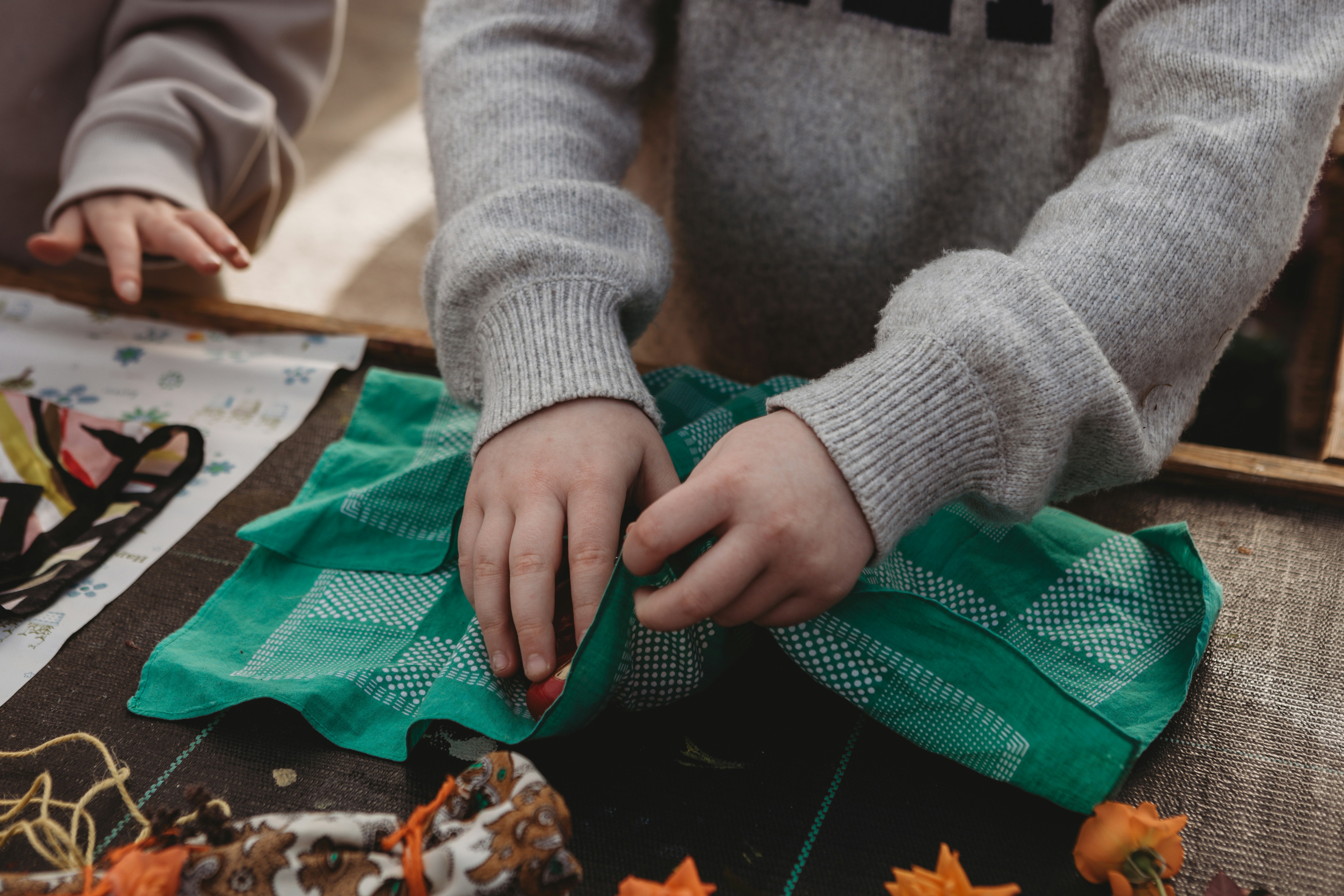 Teal Fabric Craft: Hands Work a Hidden Pattern into Textile Leaves